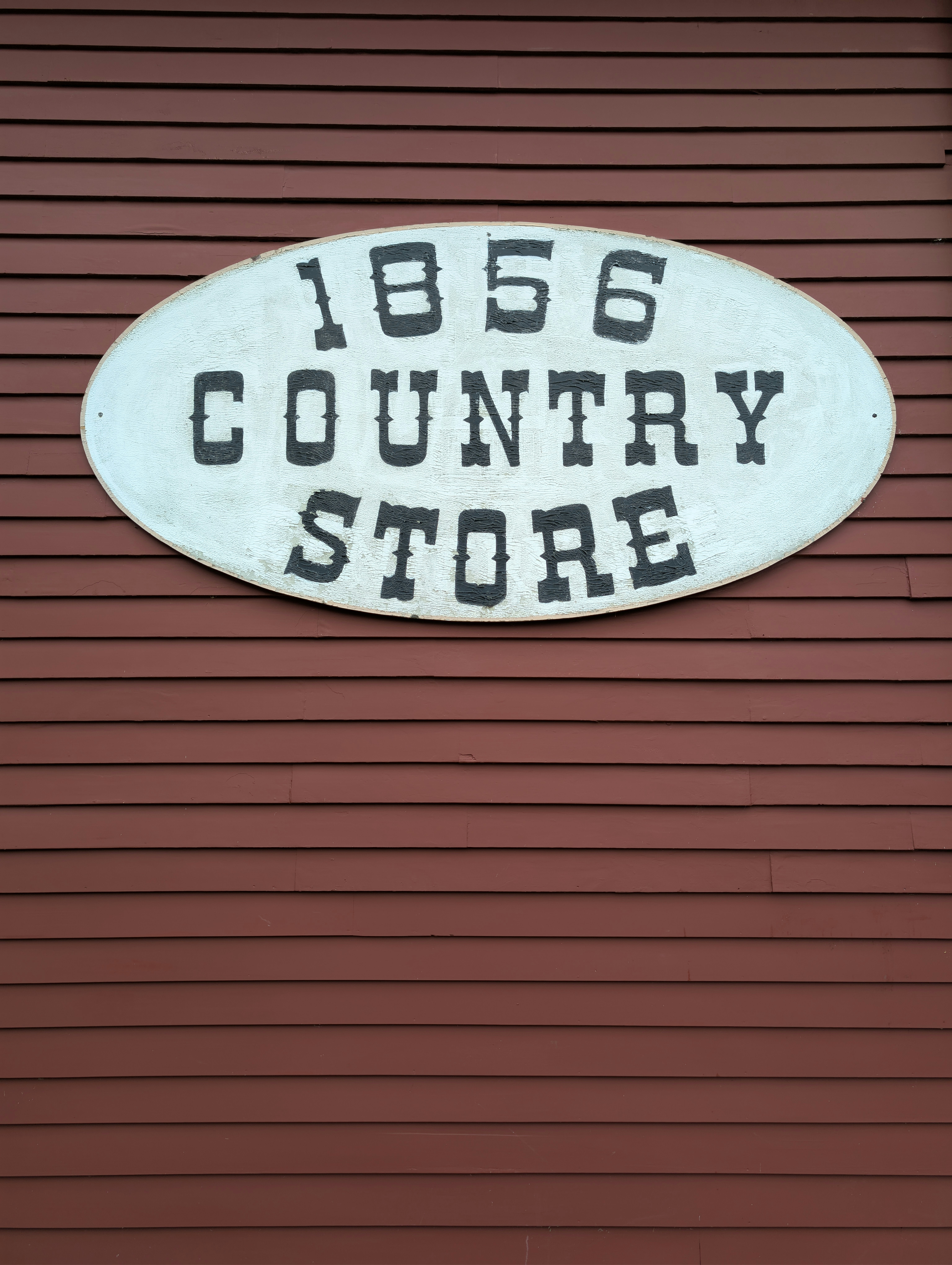 1856 country store sign on red wooden wall