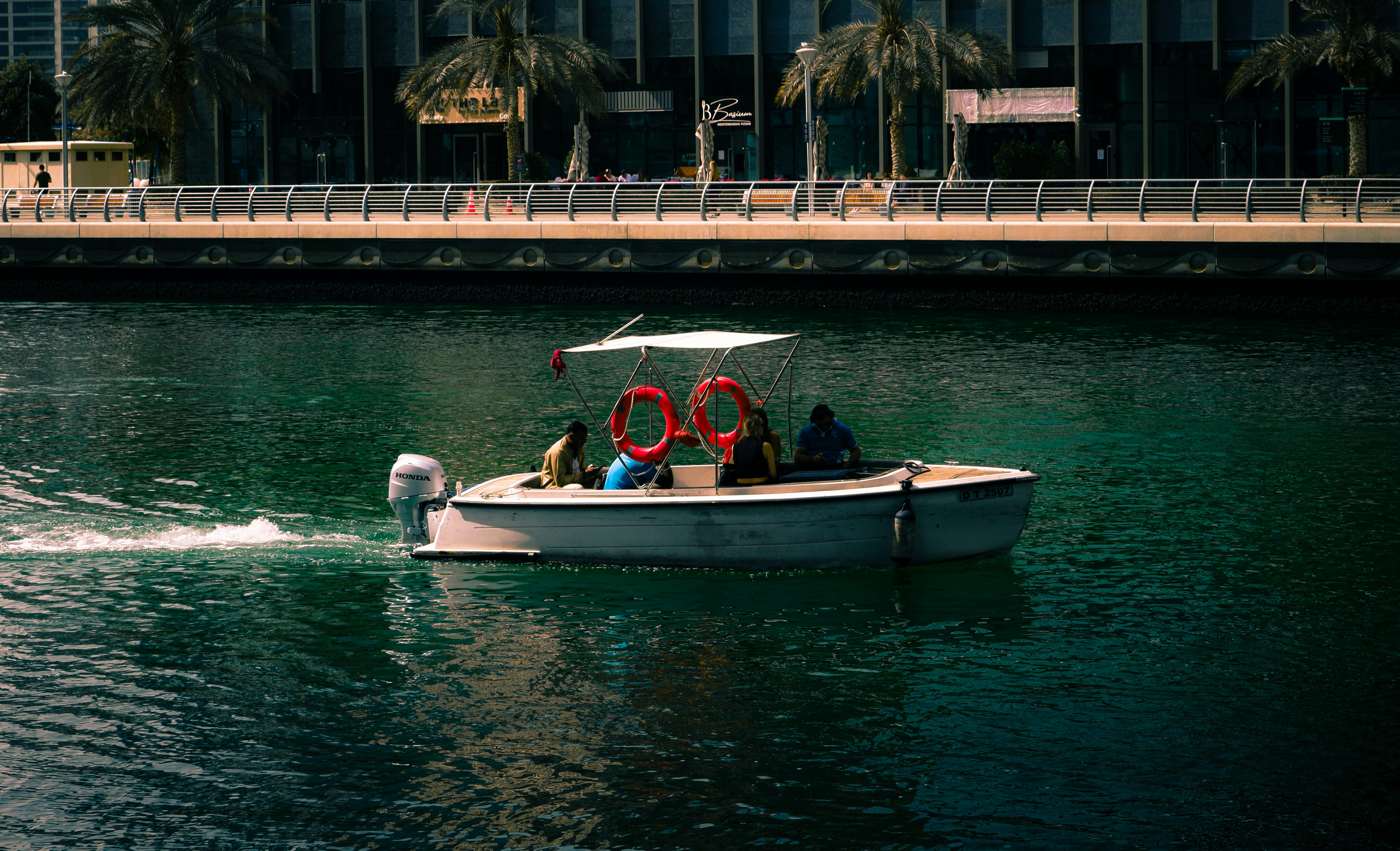People on a boat sailing on a green river.