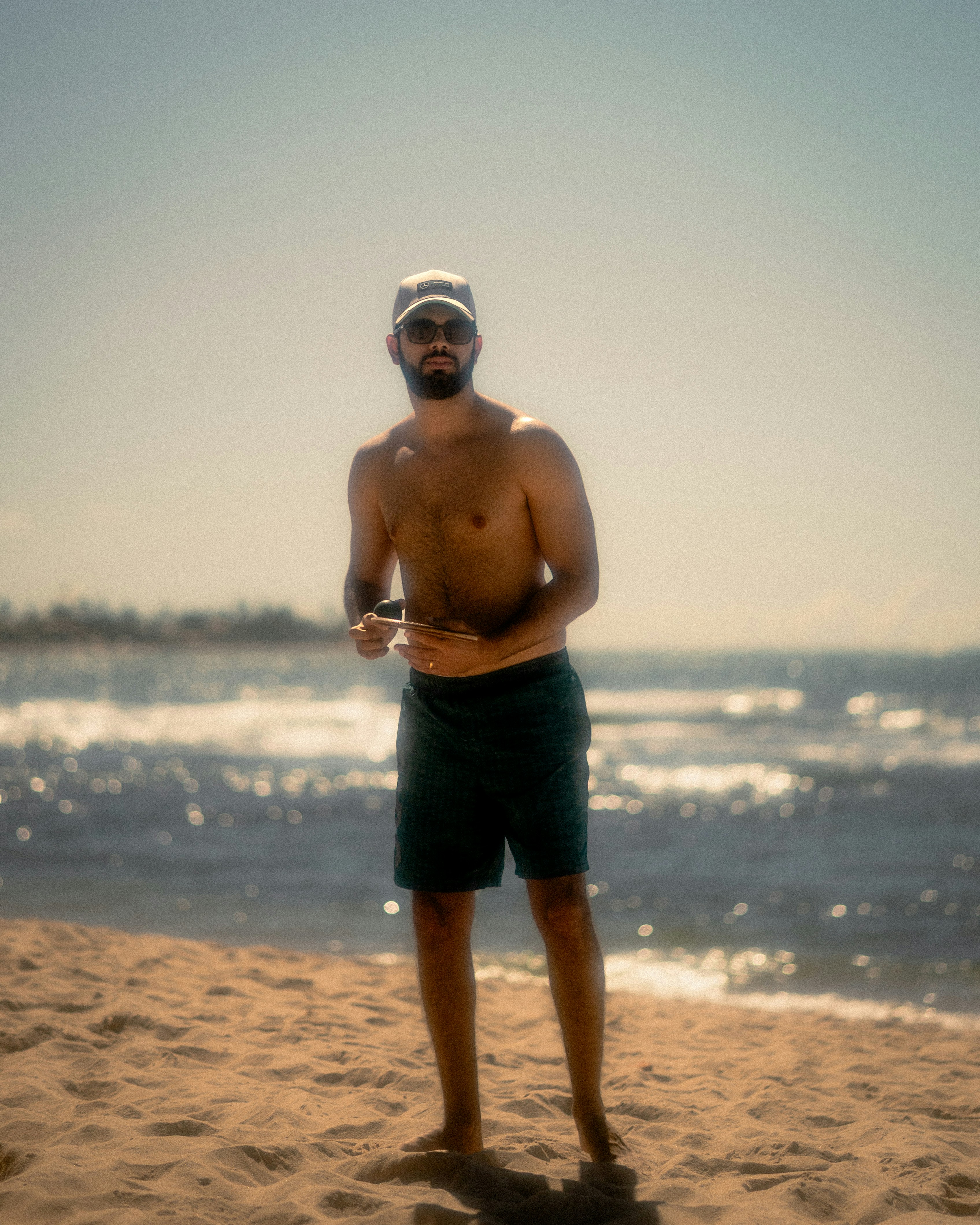 Man in sunglasses and hat on beach