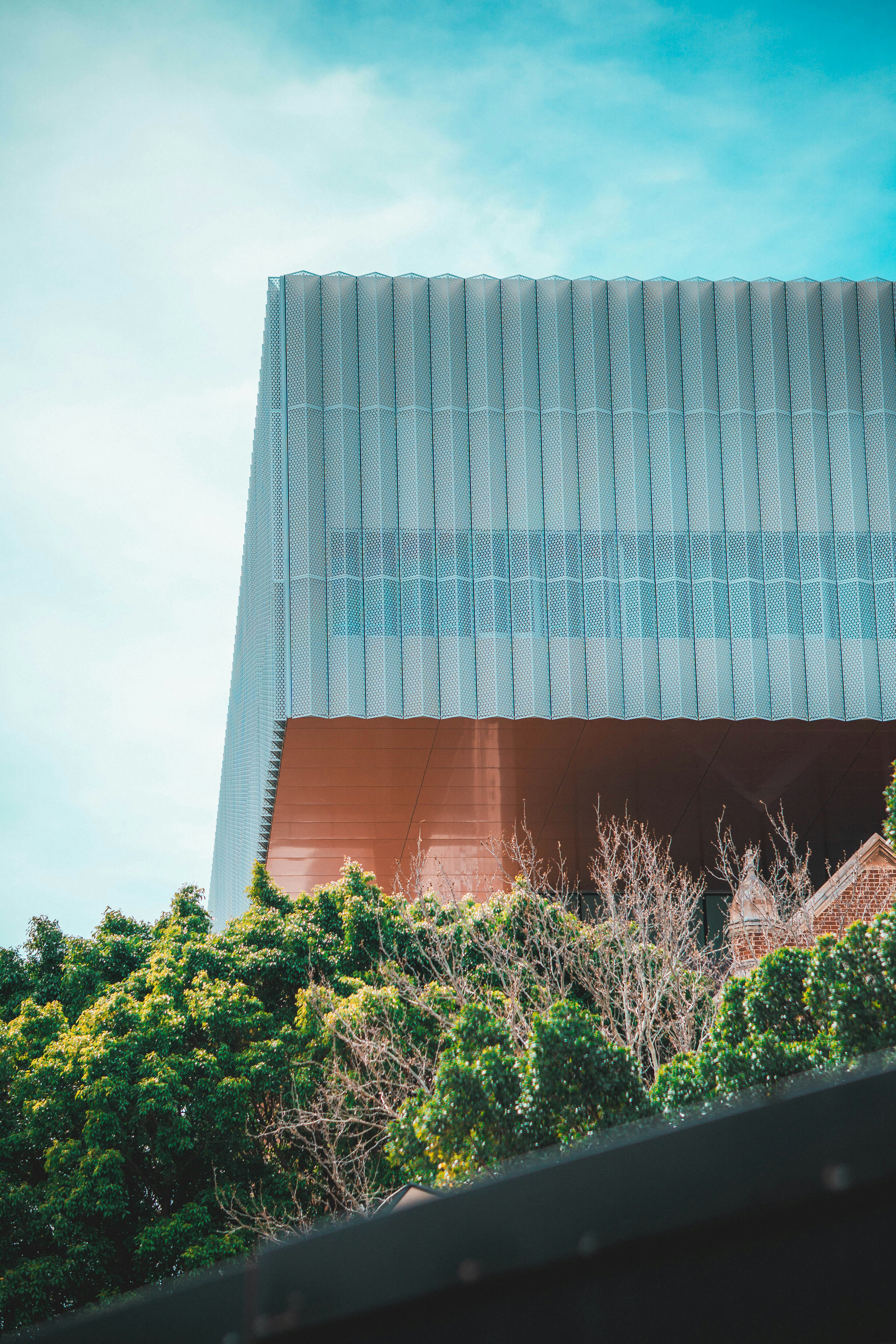 A striking architectural structure rises above lush greenery, showcasing a blend of contemporary design and natural elements.