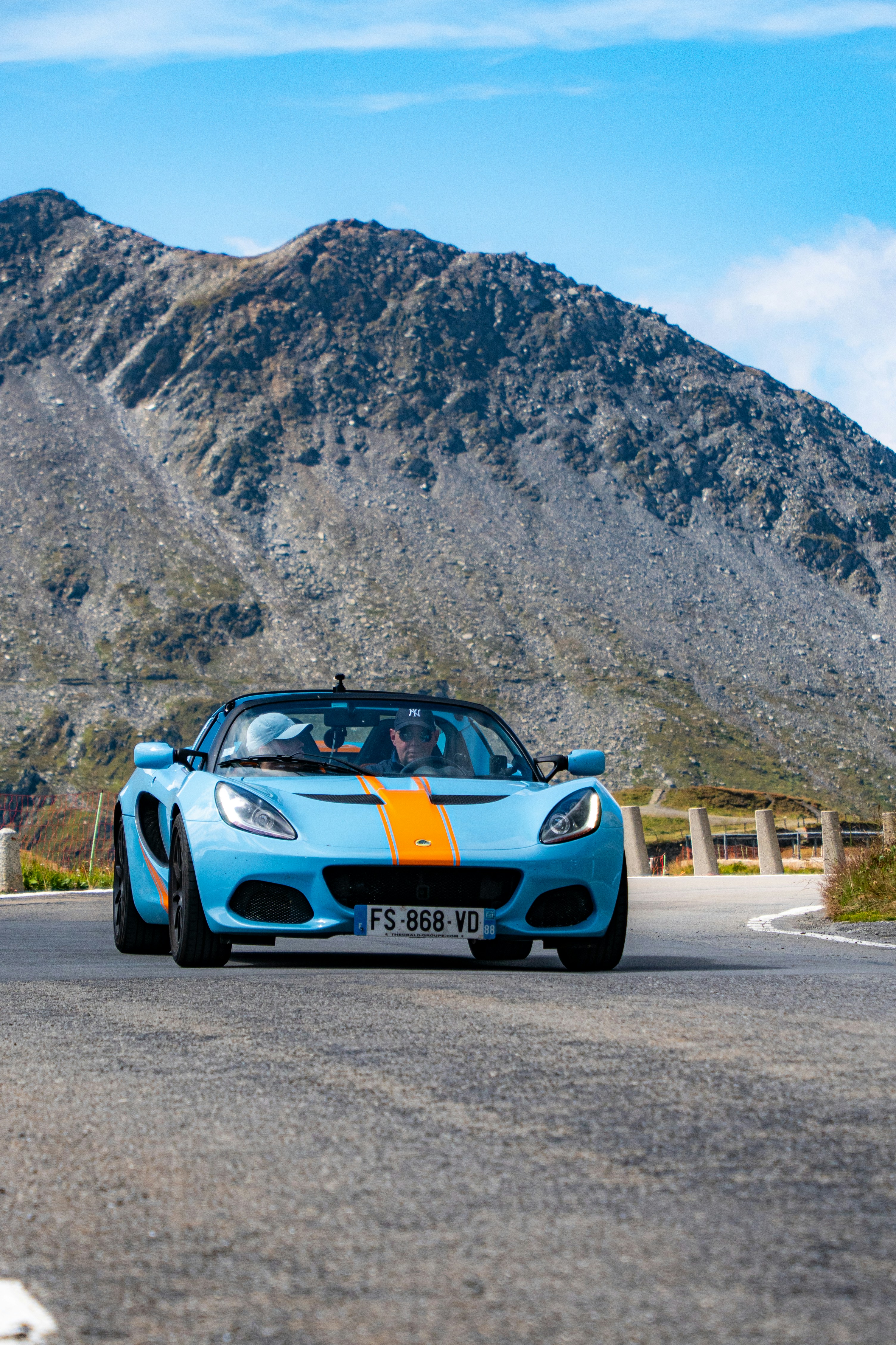 Blue sports car driving on a mountain road