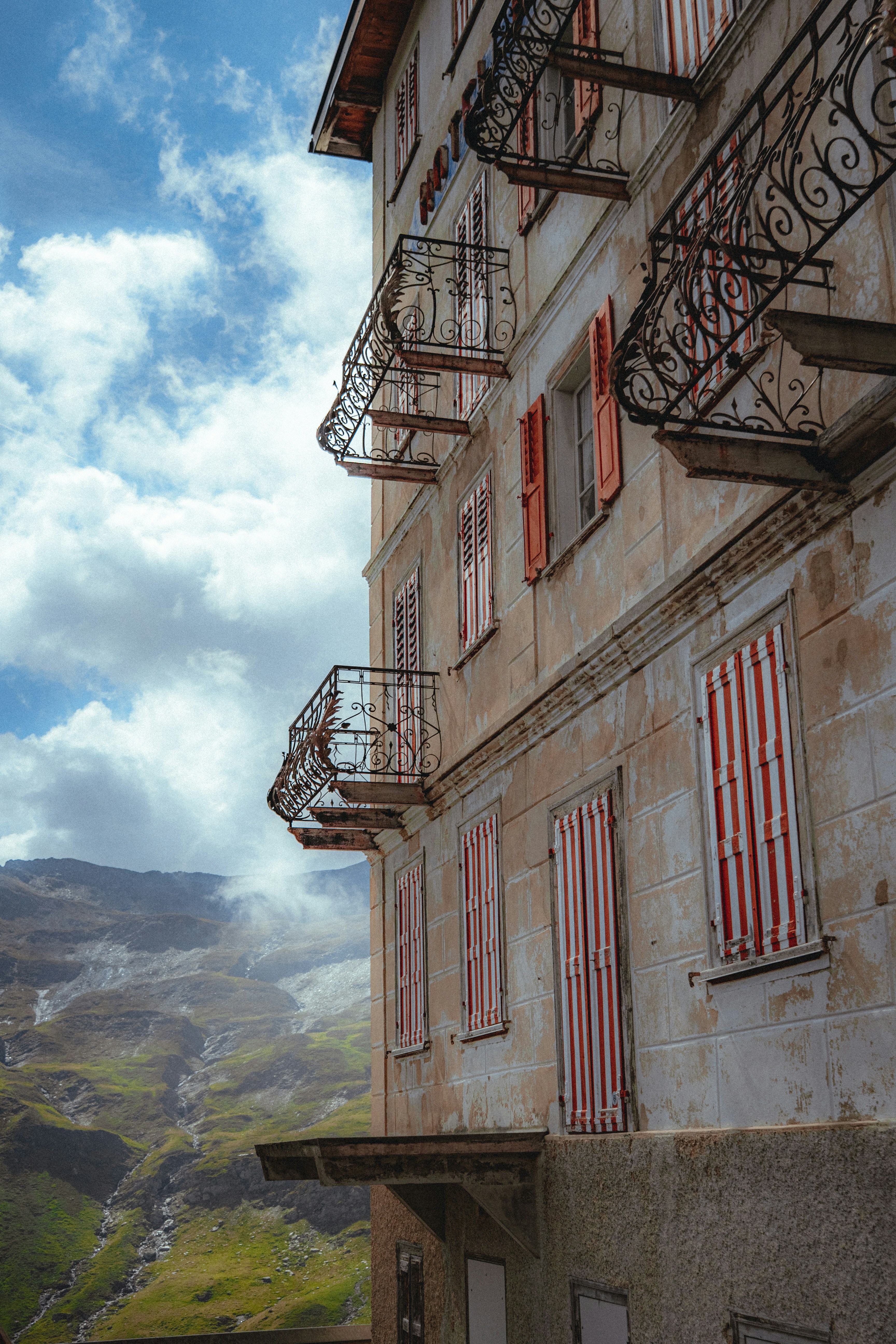 Red Shutters and Wrought-Iron Echoes on a Mountain Facade