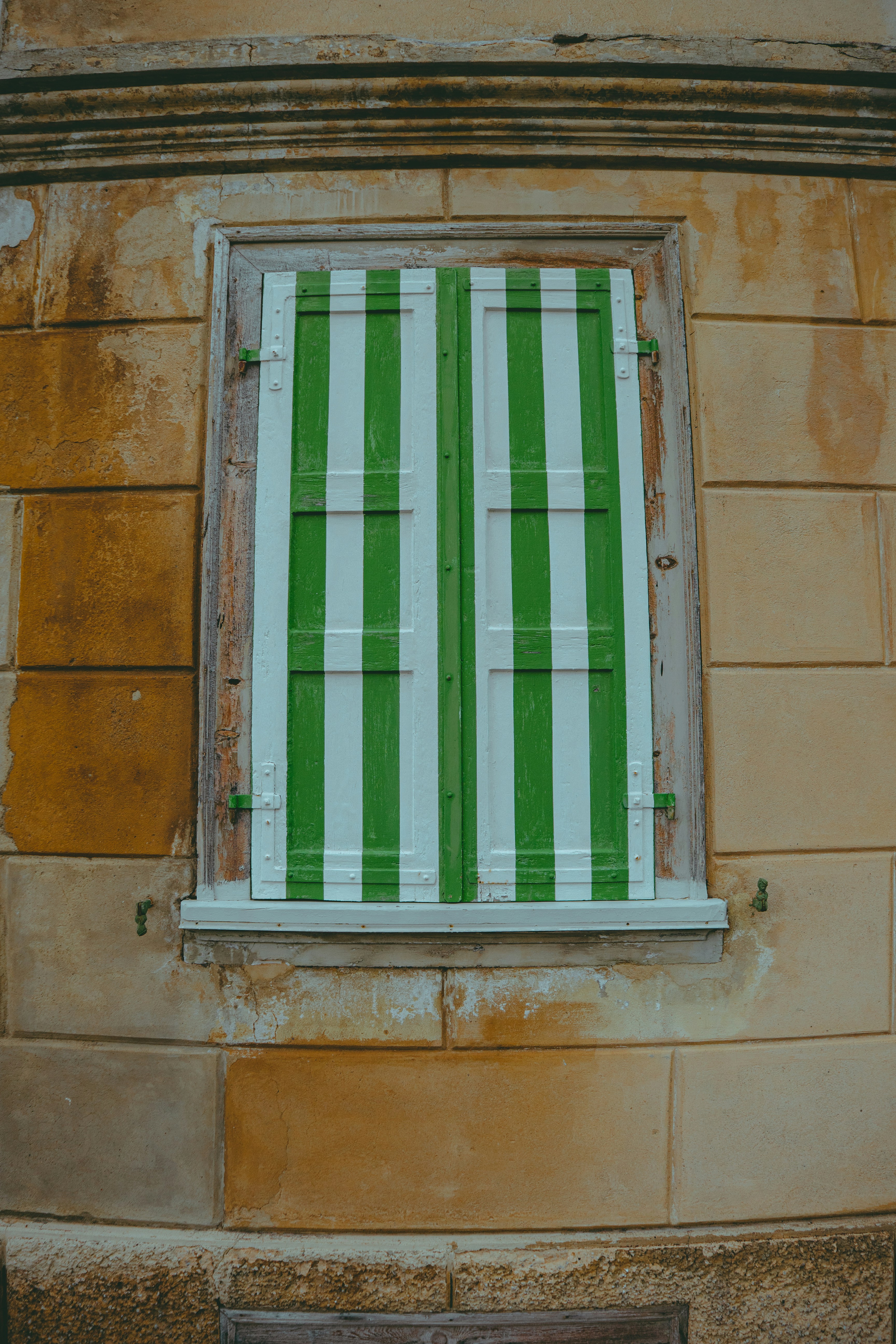 Green and white striped shutters on a building.