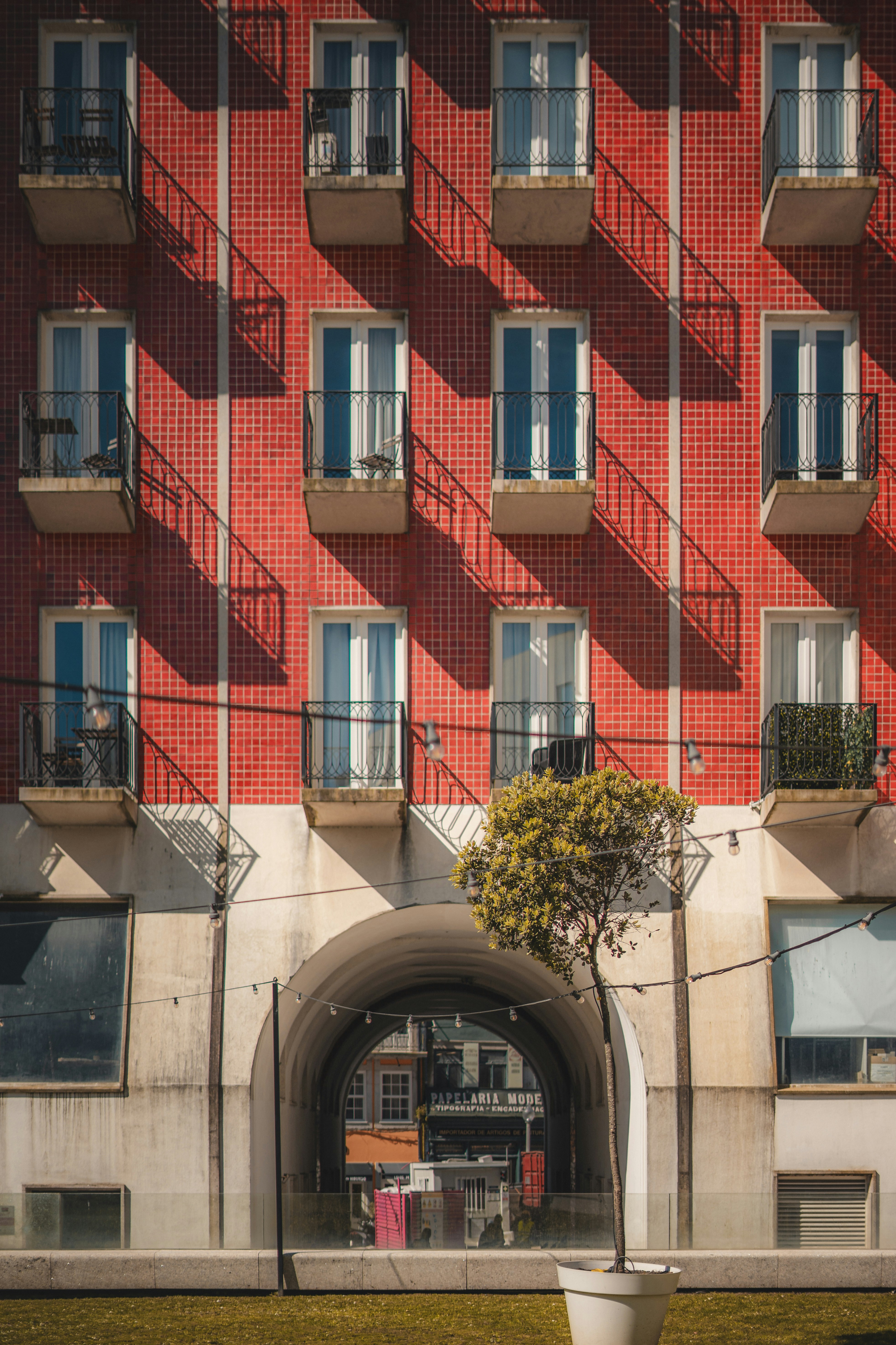 Red Brick Facade: Shadow Geometry Framing a Central Arch