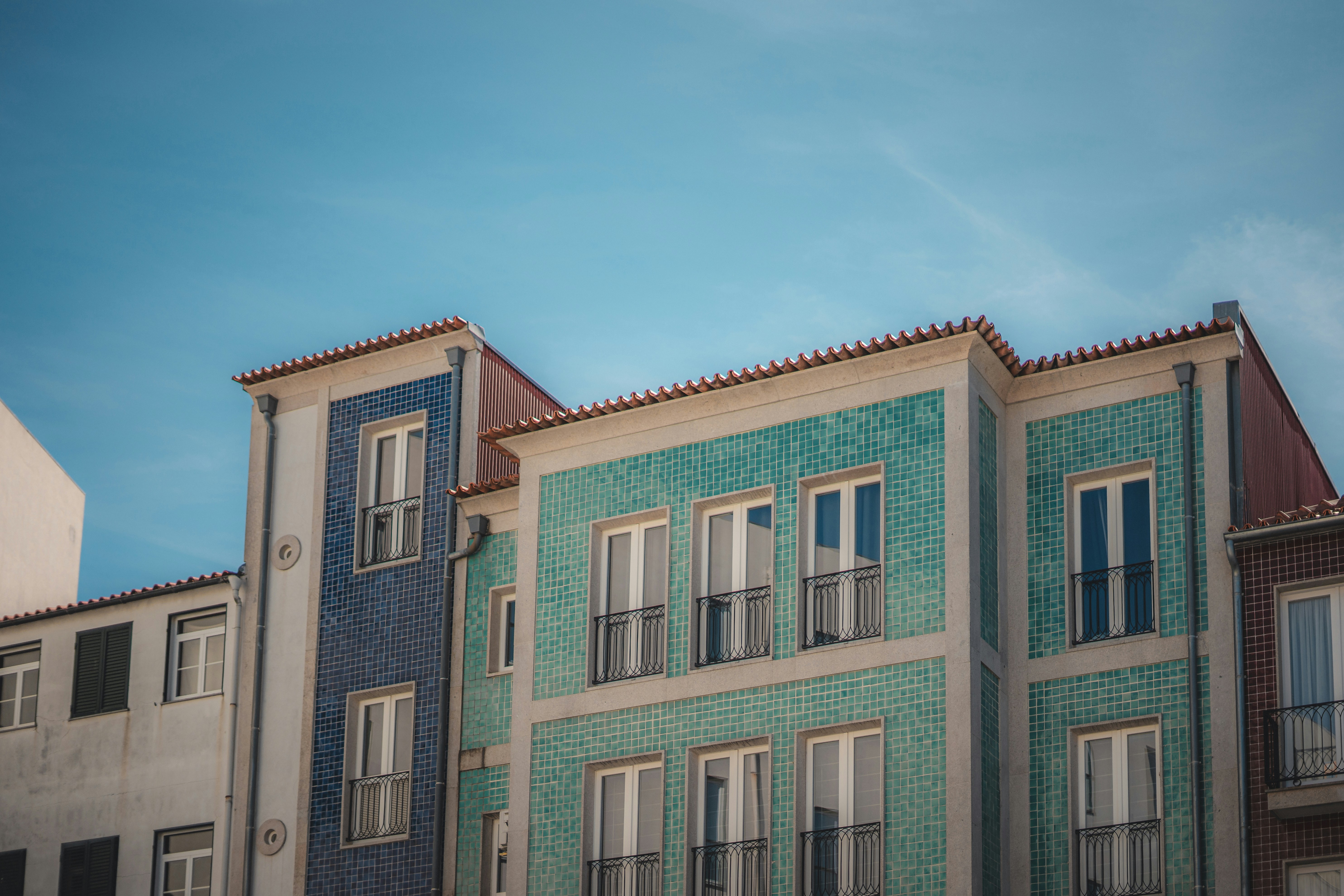 Teal Tile Facade: Balconies Under a Clear Blue Sky
