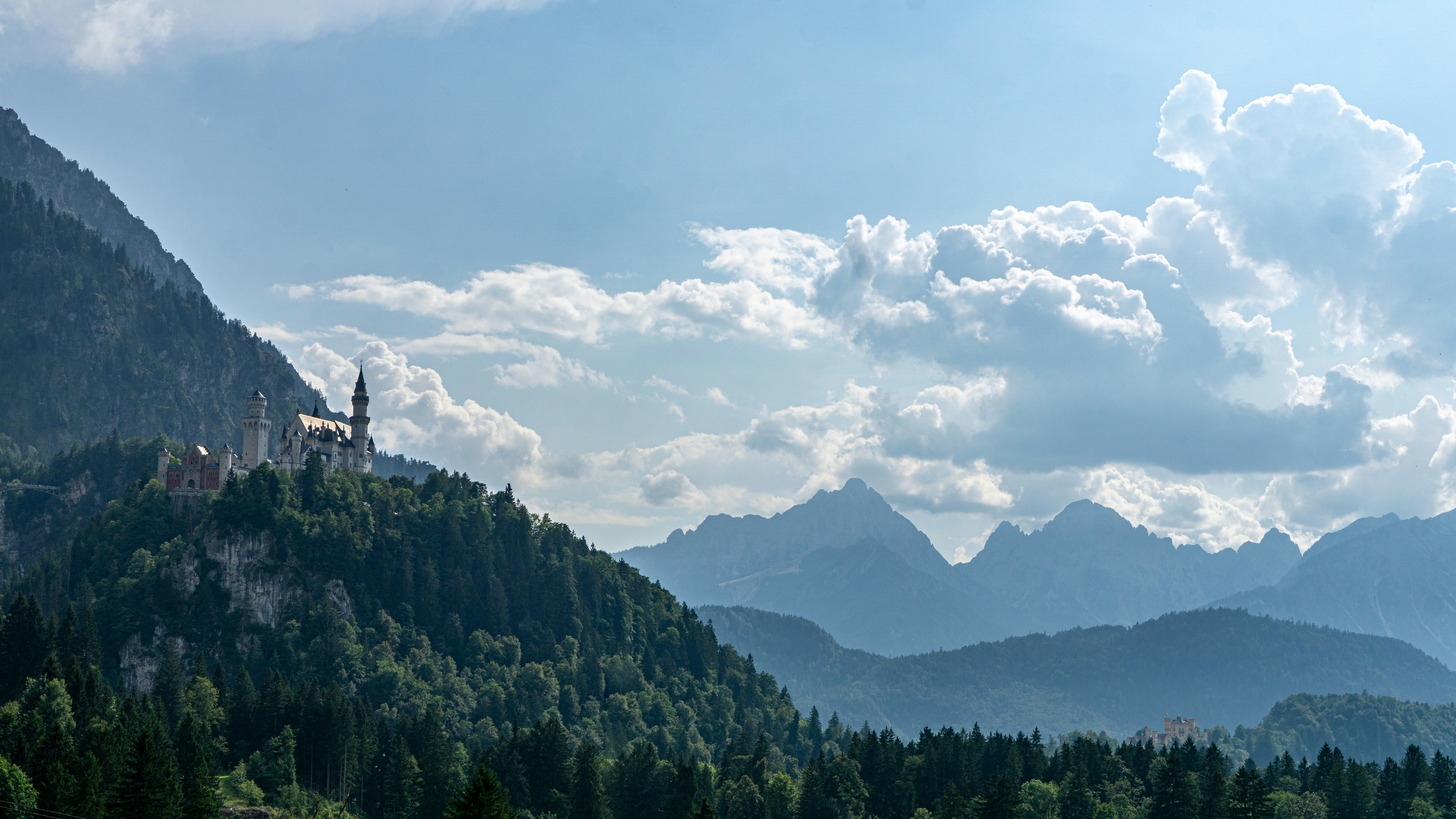 Castle on a forested hill with distant mountains