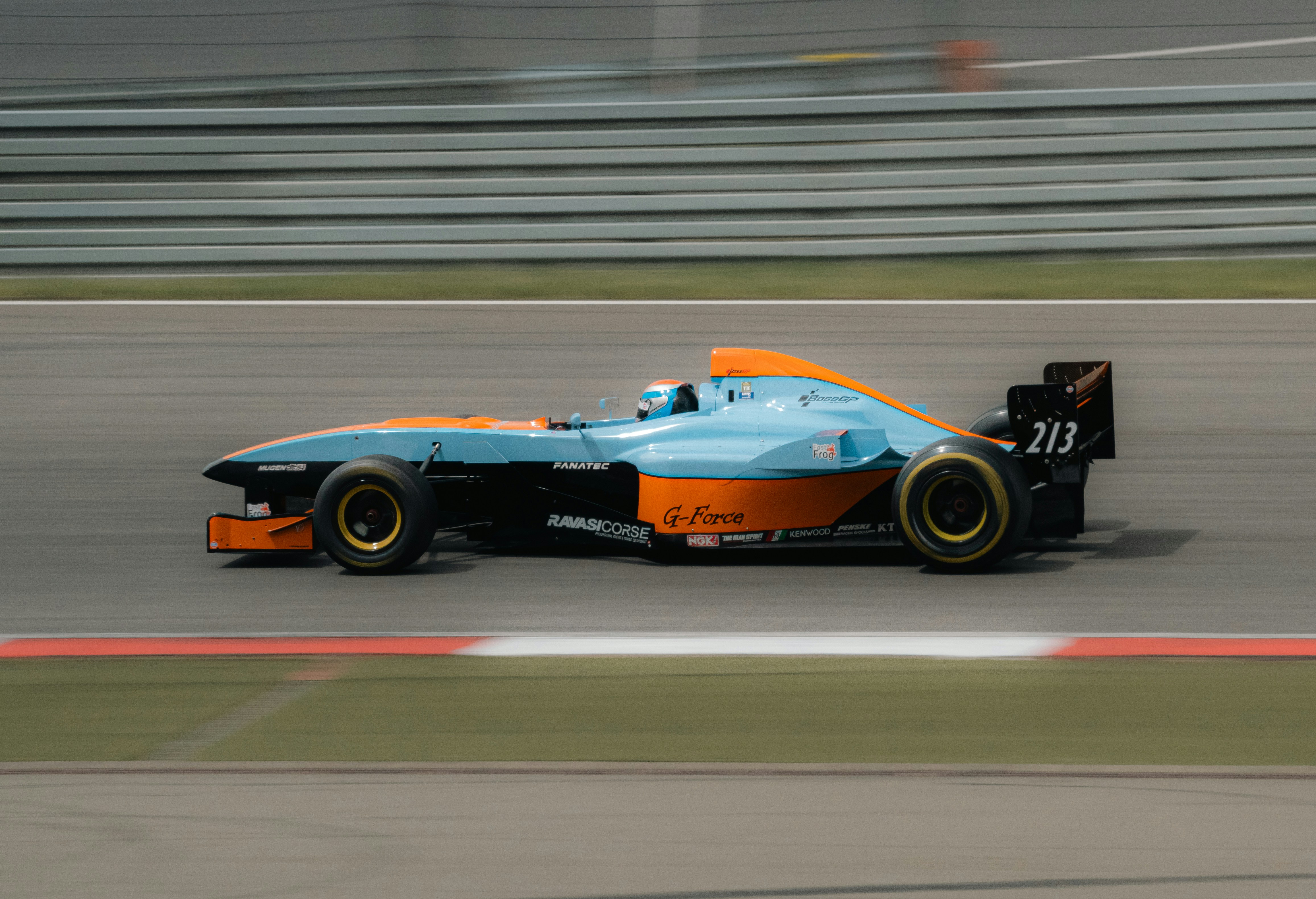 If you consider downloading this image, a gentle reminder that any brands or logos depicted are protected by trademark. Please keep this in mind for your projects, especially if they are commercial — and thanks in advance for downloading! | Race car speeding on a track with motion blur.