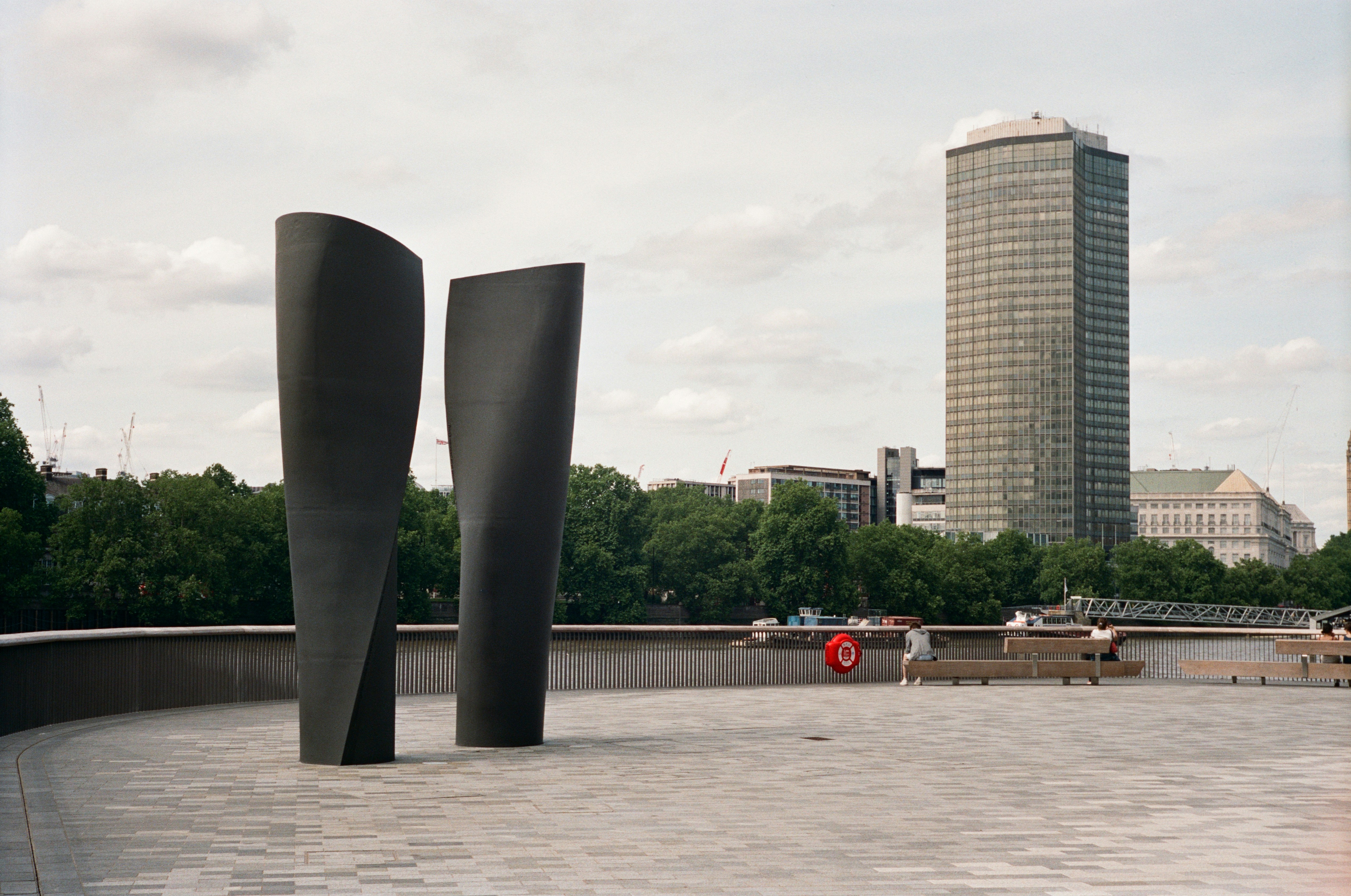 London's South Bank in summer afternoon light, capturing modern sculpture and urban skyline.
