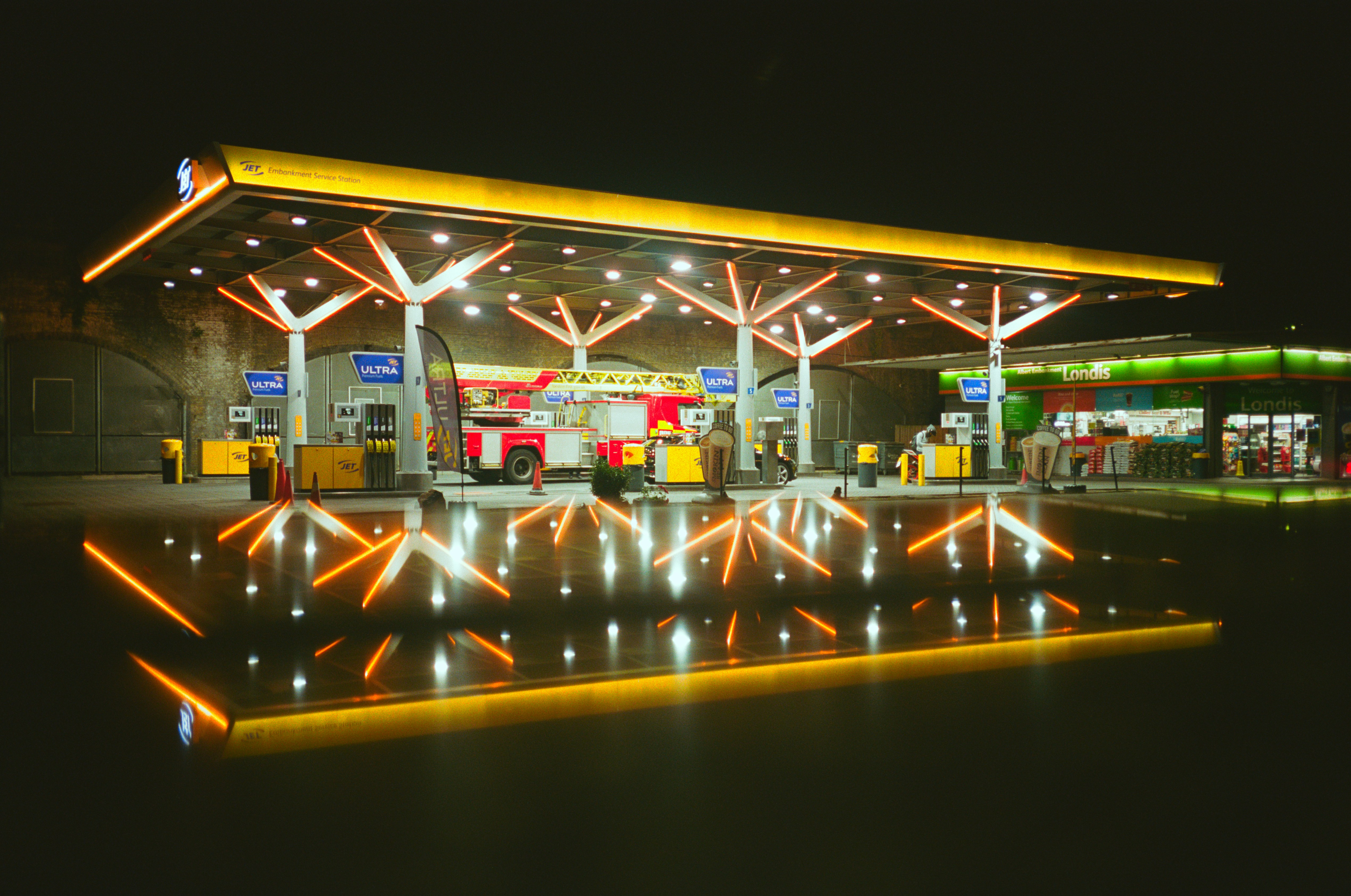 Nighttime glow at a vibrant London gas station, reflecting urban life in autumn.