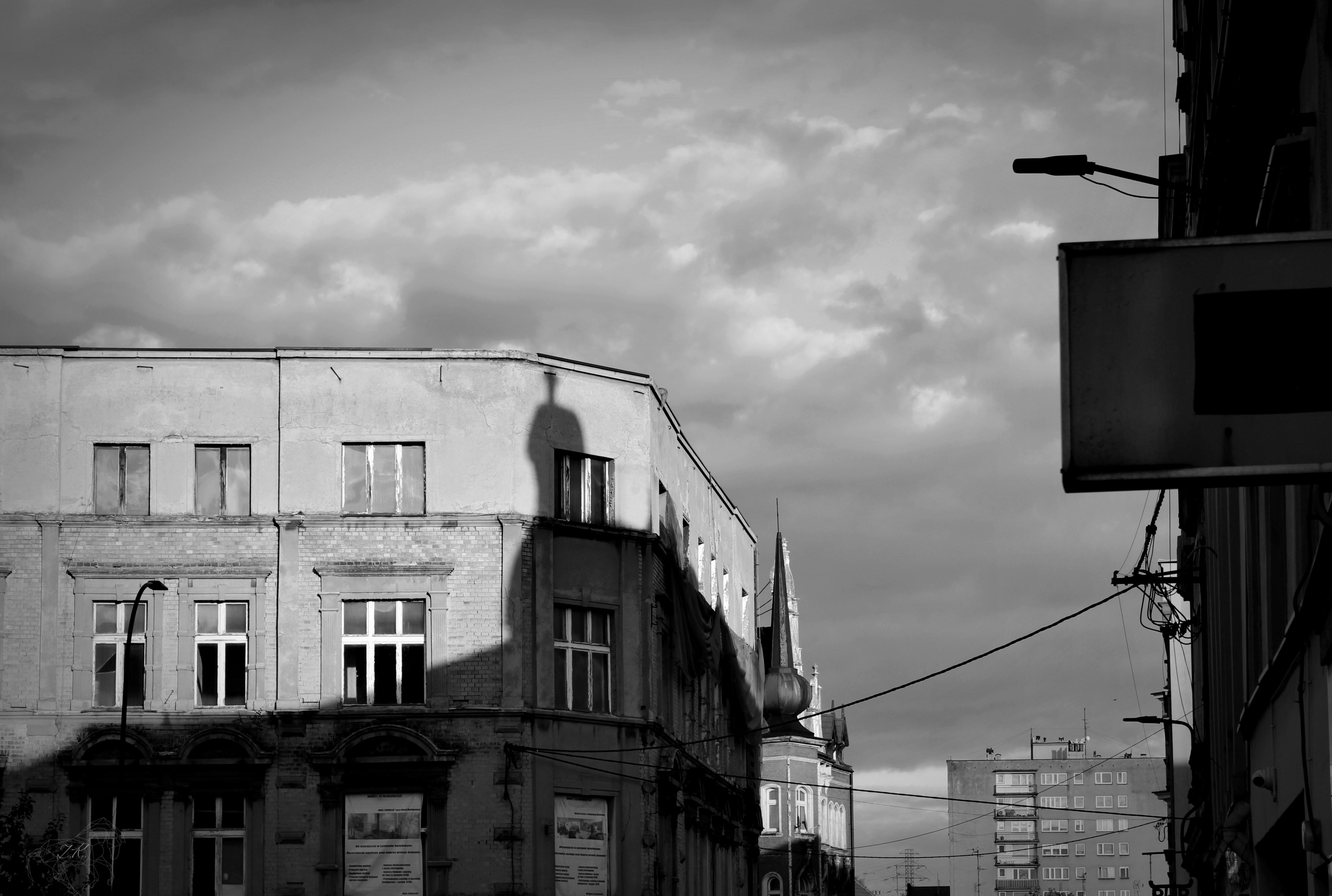City life. | Angular building facade with dramatic shadows and clouds