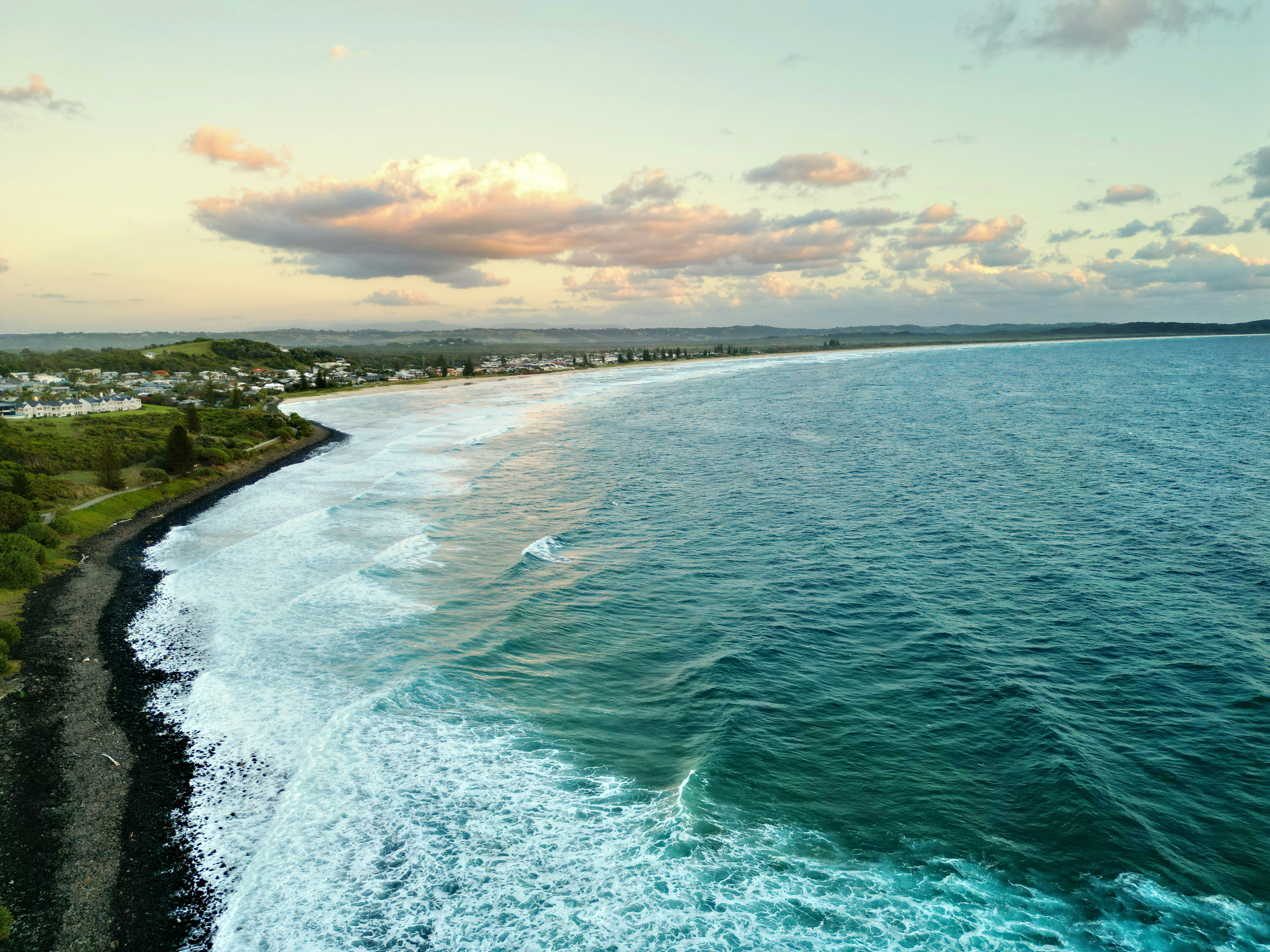 Coastal town with ocean waves and distant hills