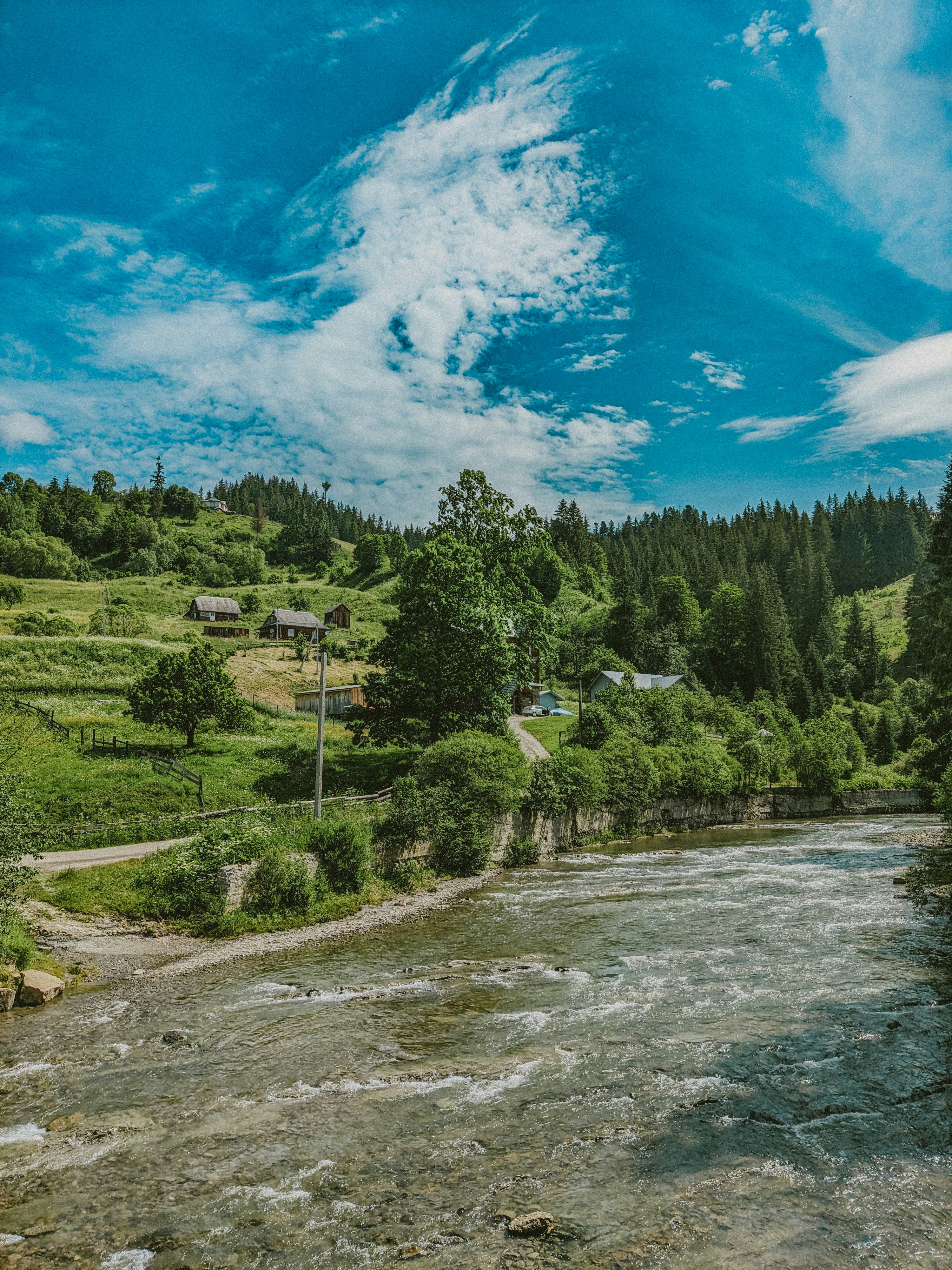 Alpine Riverbank Hamlet Under a Cobalt Sky