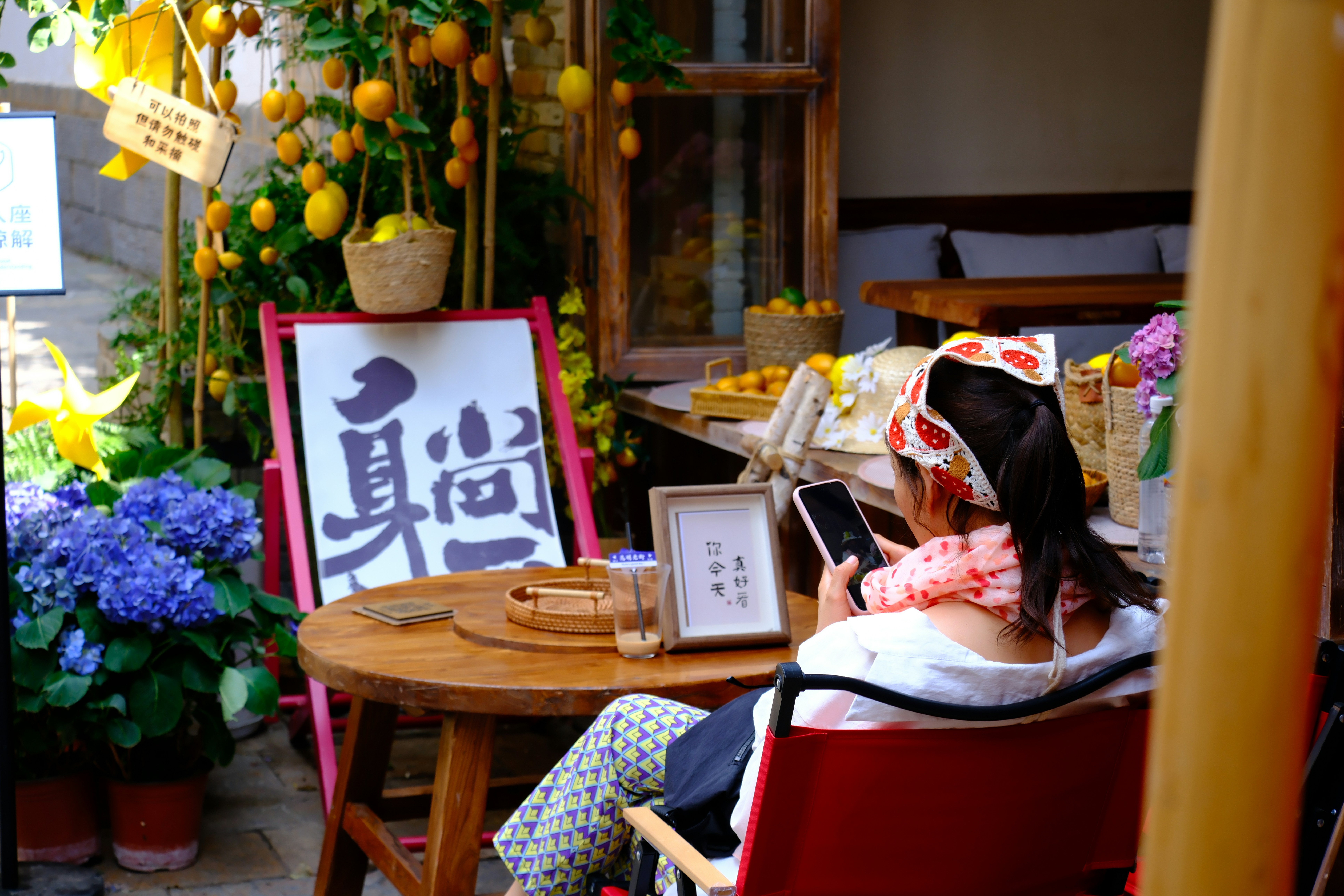Woman sitting at table with lemons and flowers.