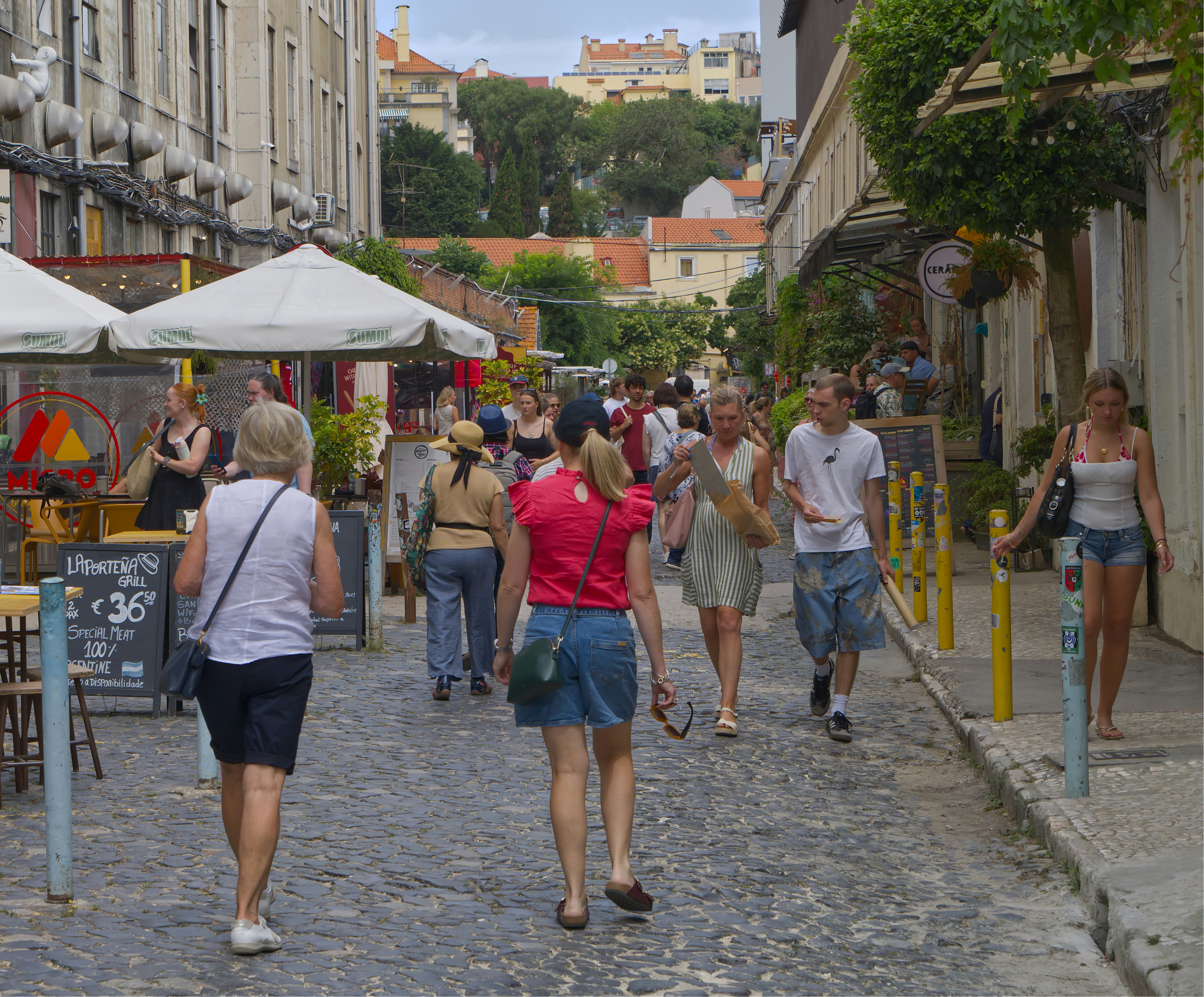 Je continue ma balade au cœur de LX Factory dans cette ruelle pavée entre les terrasses et les boutiques créatives. Flâneurs, habitants et touristes se croisent dans une atmosphère estivale, rythmée par les conversations, l’odeur des grillades et les façades industrielles réinventées. Un concentré de l’esprit bohème et branché de Lisbonne.