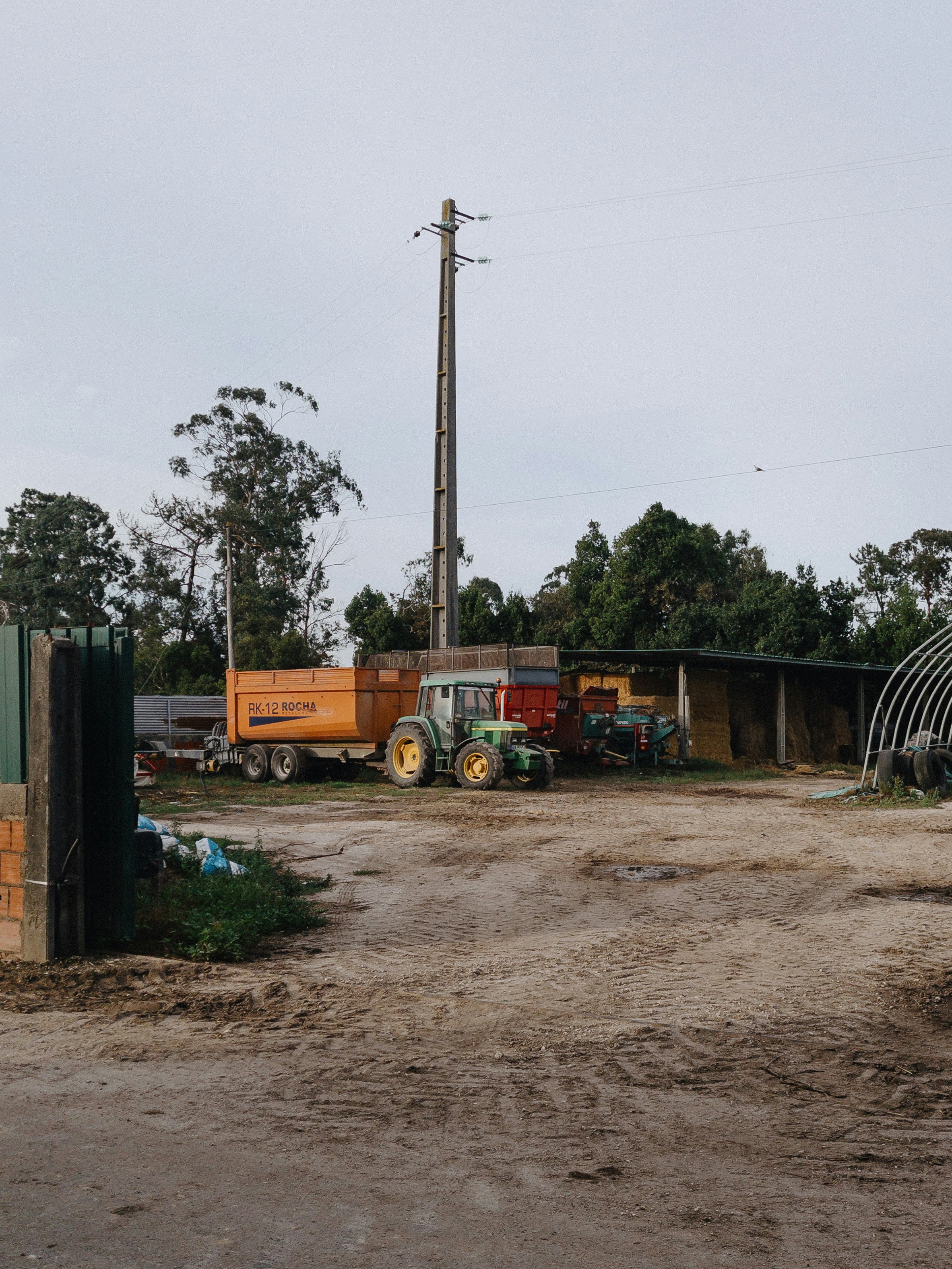 Dusty Farmyard Scene with Tractor and Dump Trailer
