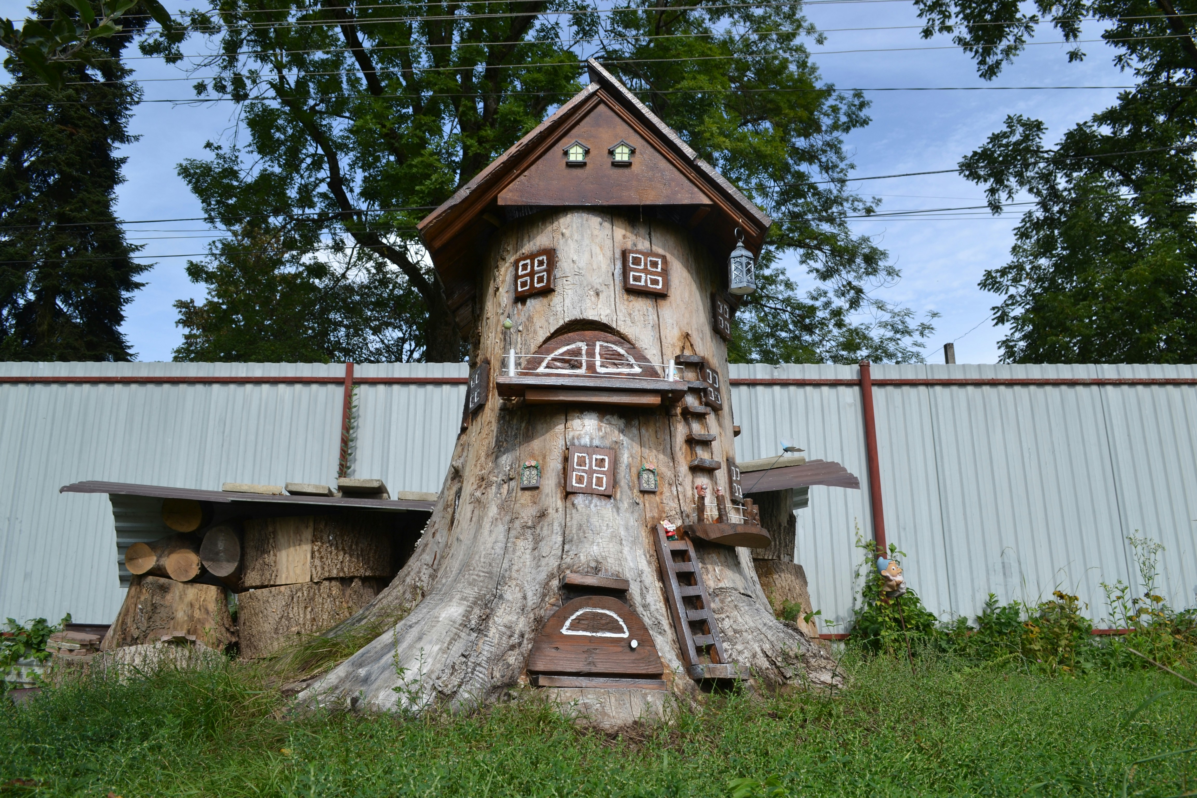 Whimsical tree stump house with charming windows and doors. photo ...