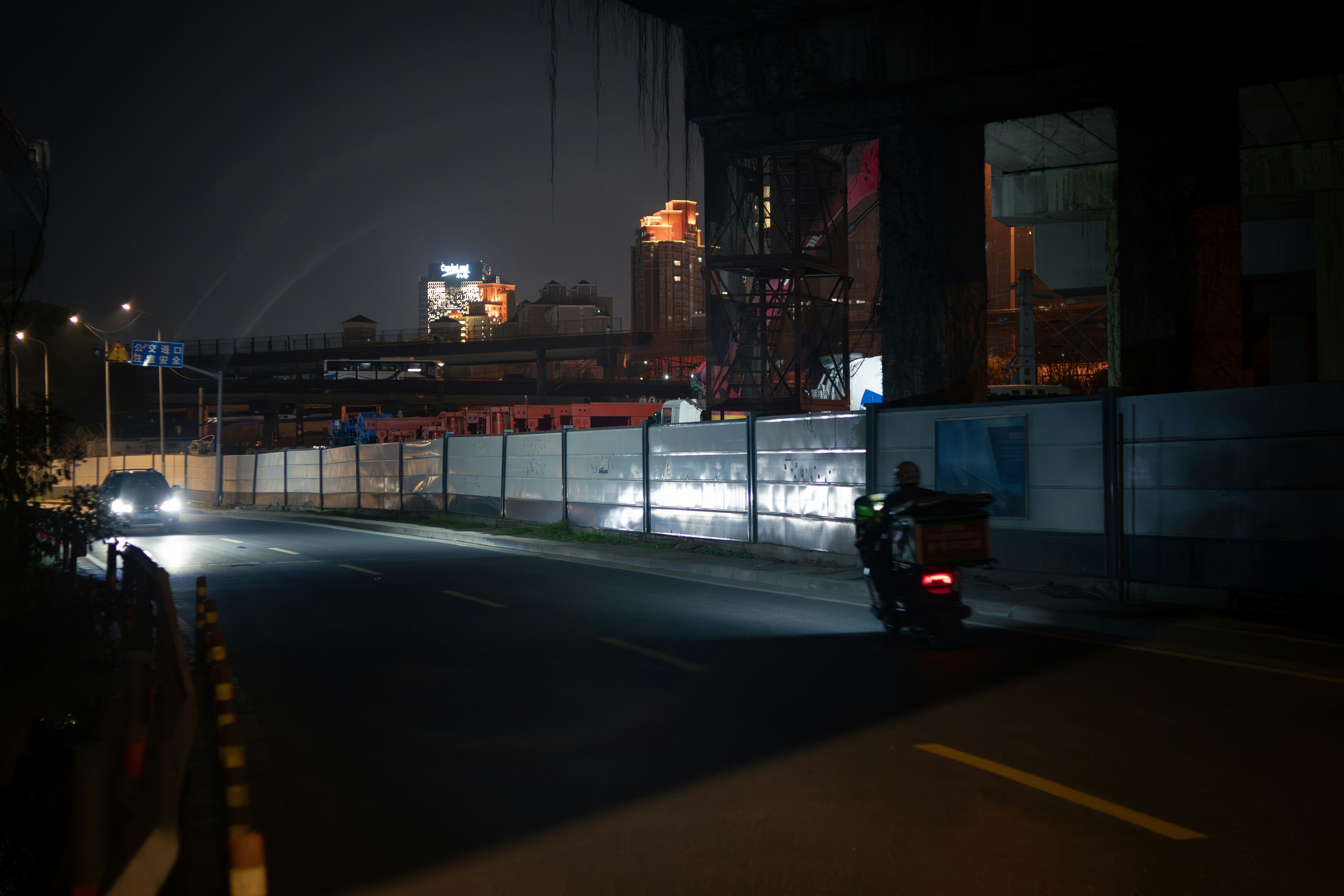 Motorcycle rider on a dark city street at night