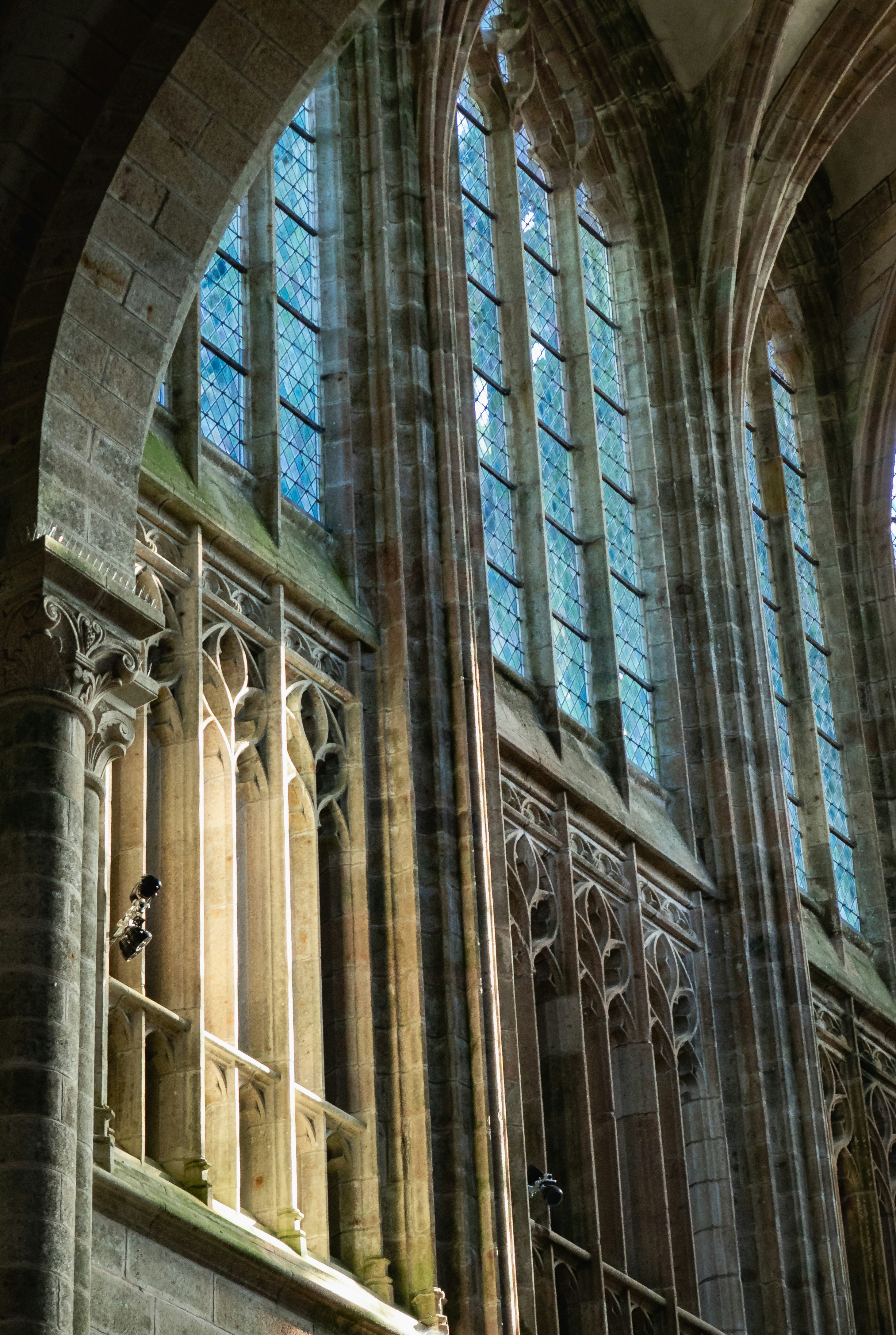 Intricate stone architecture illuminated by soft light filtering through vibrant stained glass windows.