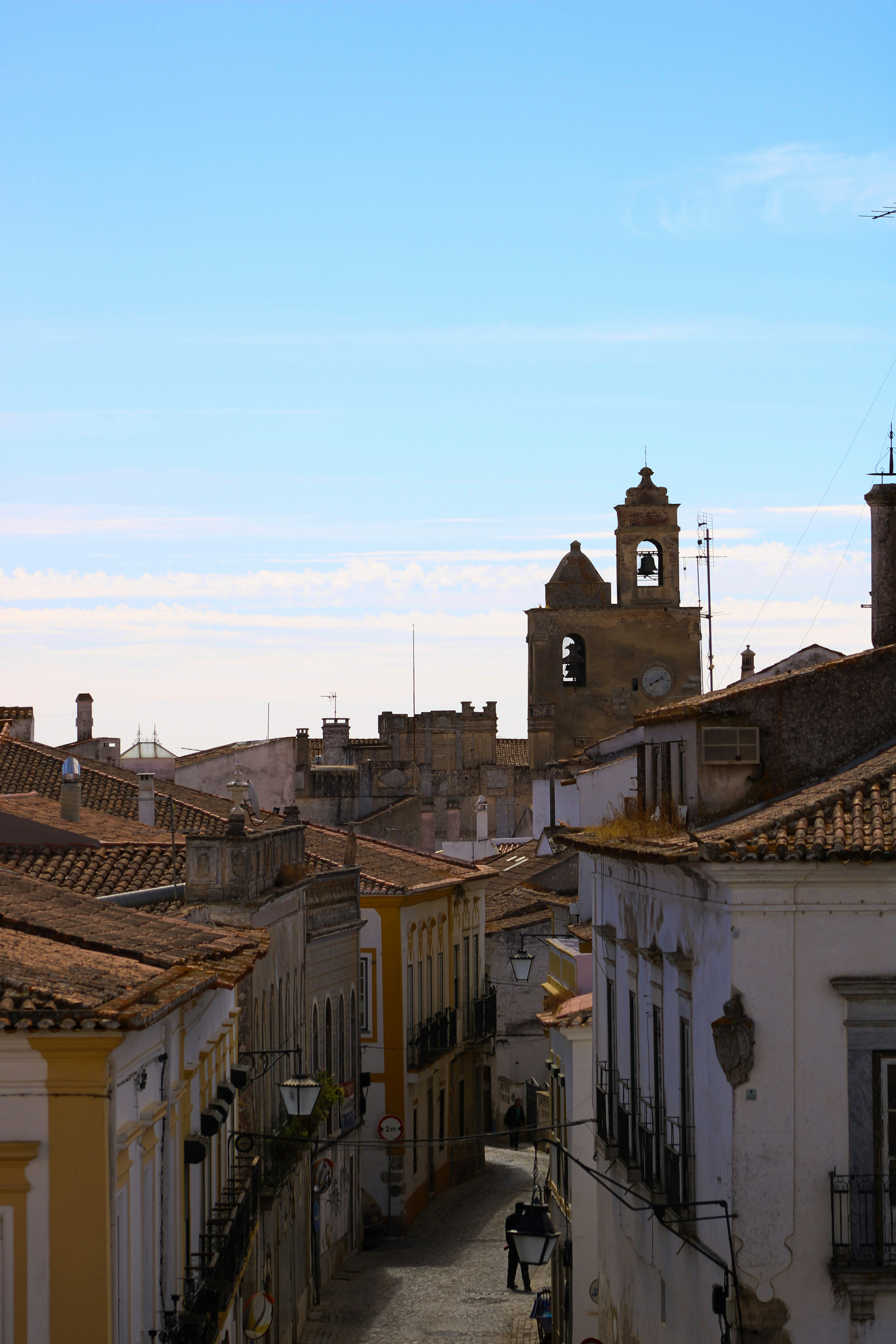 Narrow street in a european town with bell tower.