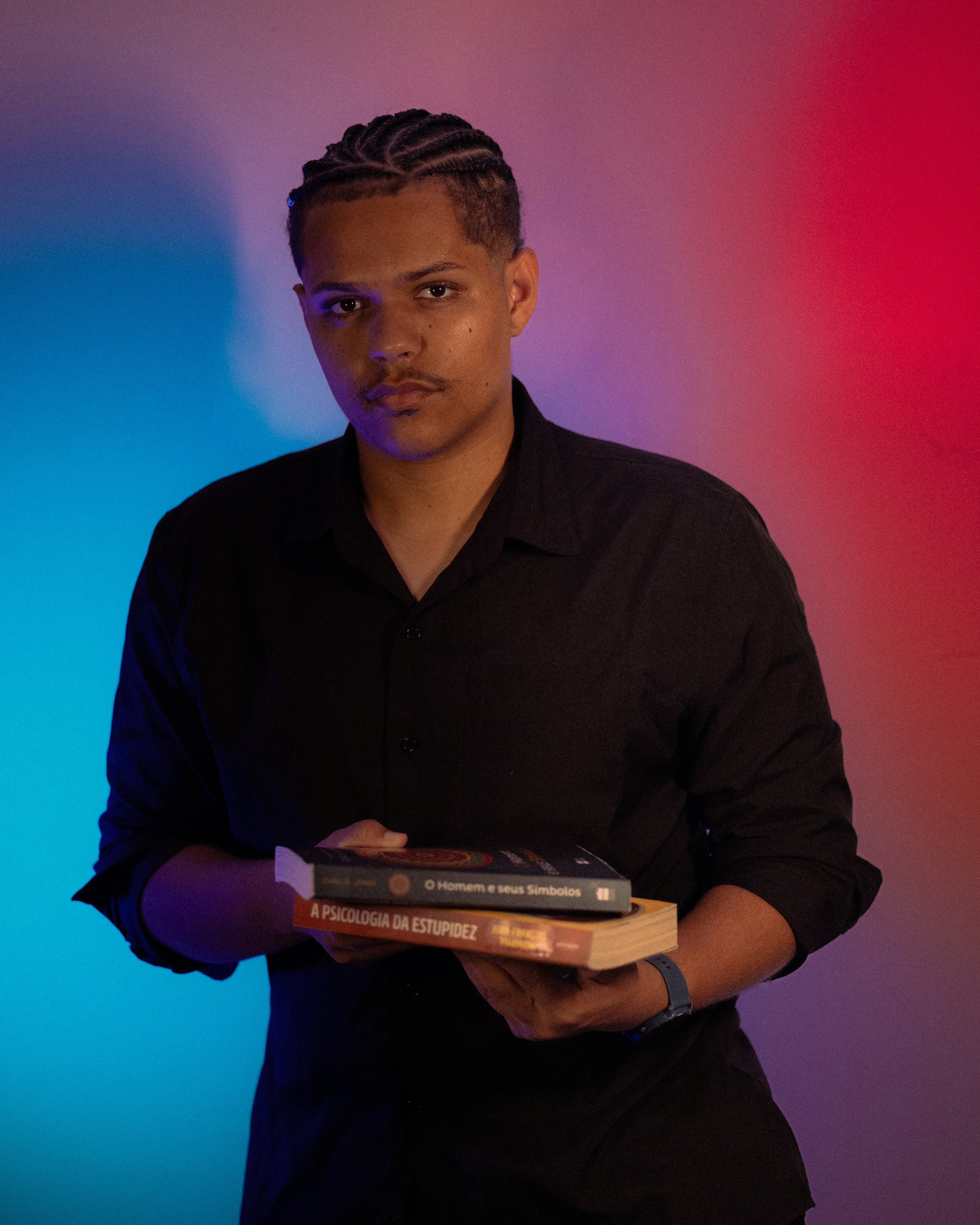 Books in Hand, Neon Backdrop: A Portrait at the Intersection of Focus and Color