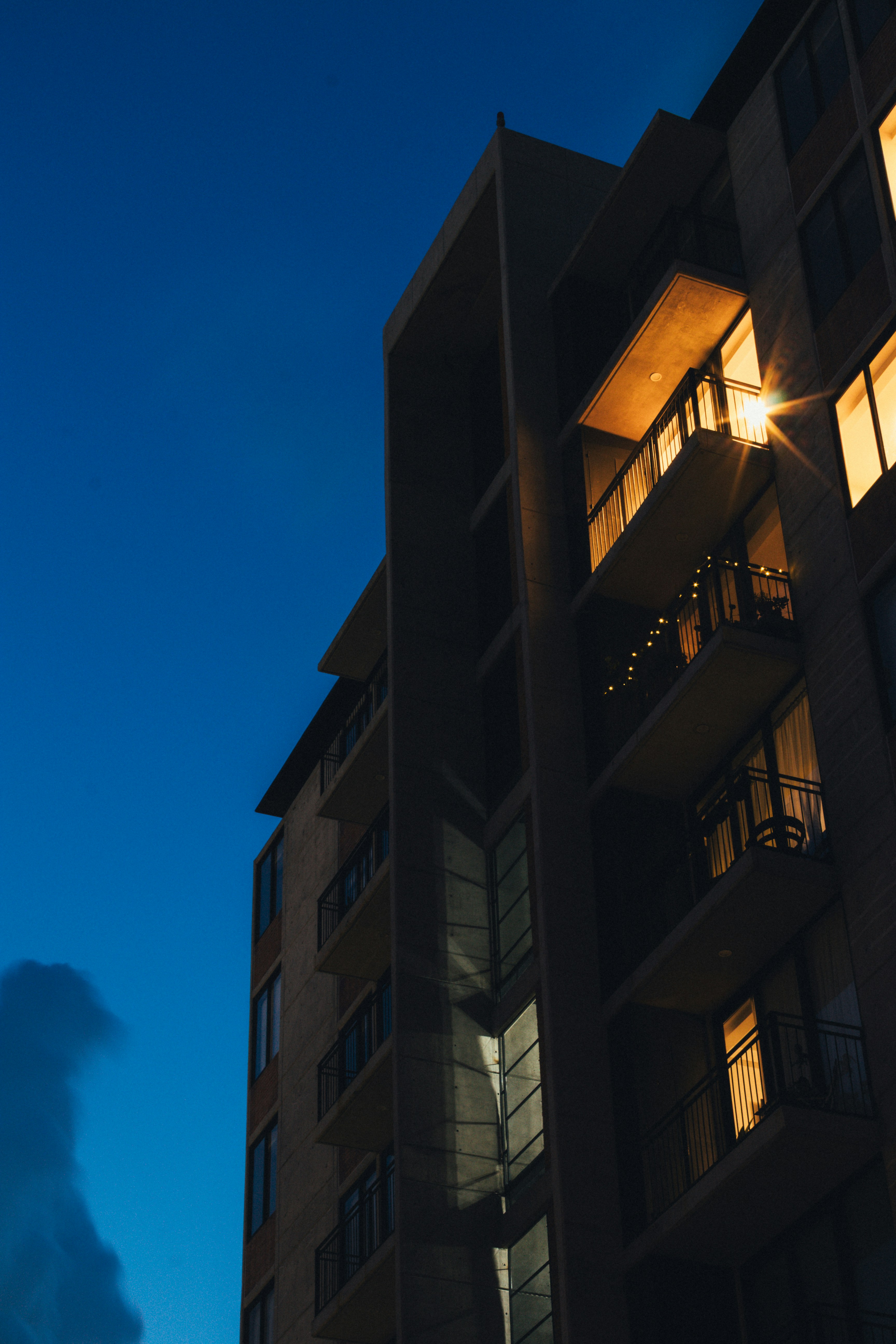 Blue Hour Facade: Warm Balcony Lights Ignite a Quiet High-Rise