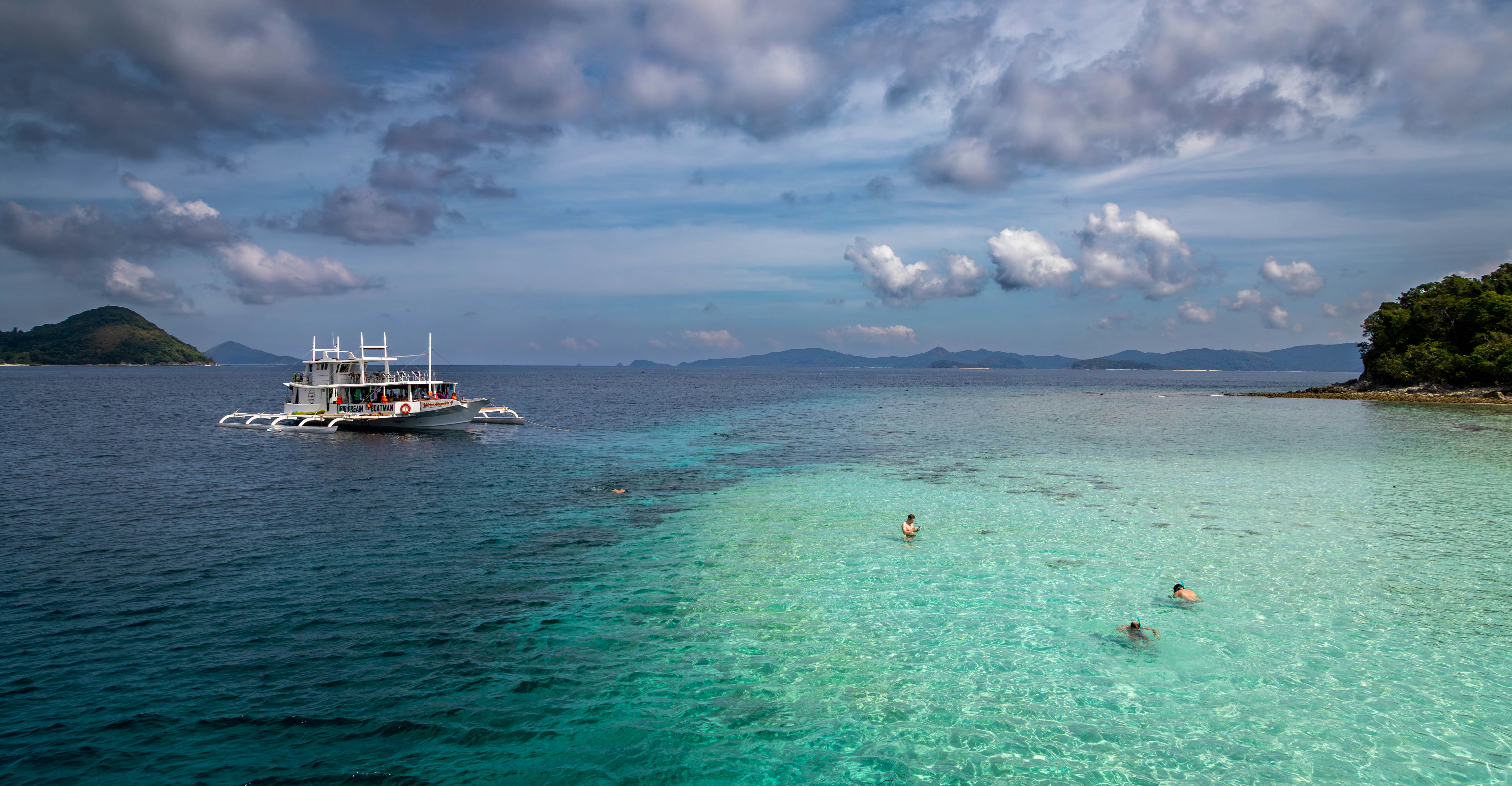 Turquoise Tide: A White Vessel Anchored at the Edge of Crystal Caribbean Waters