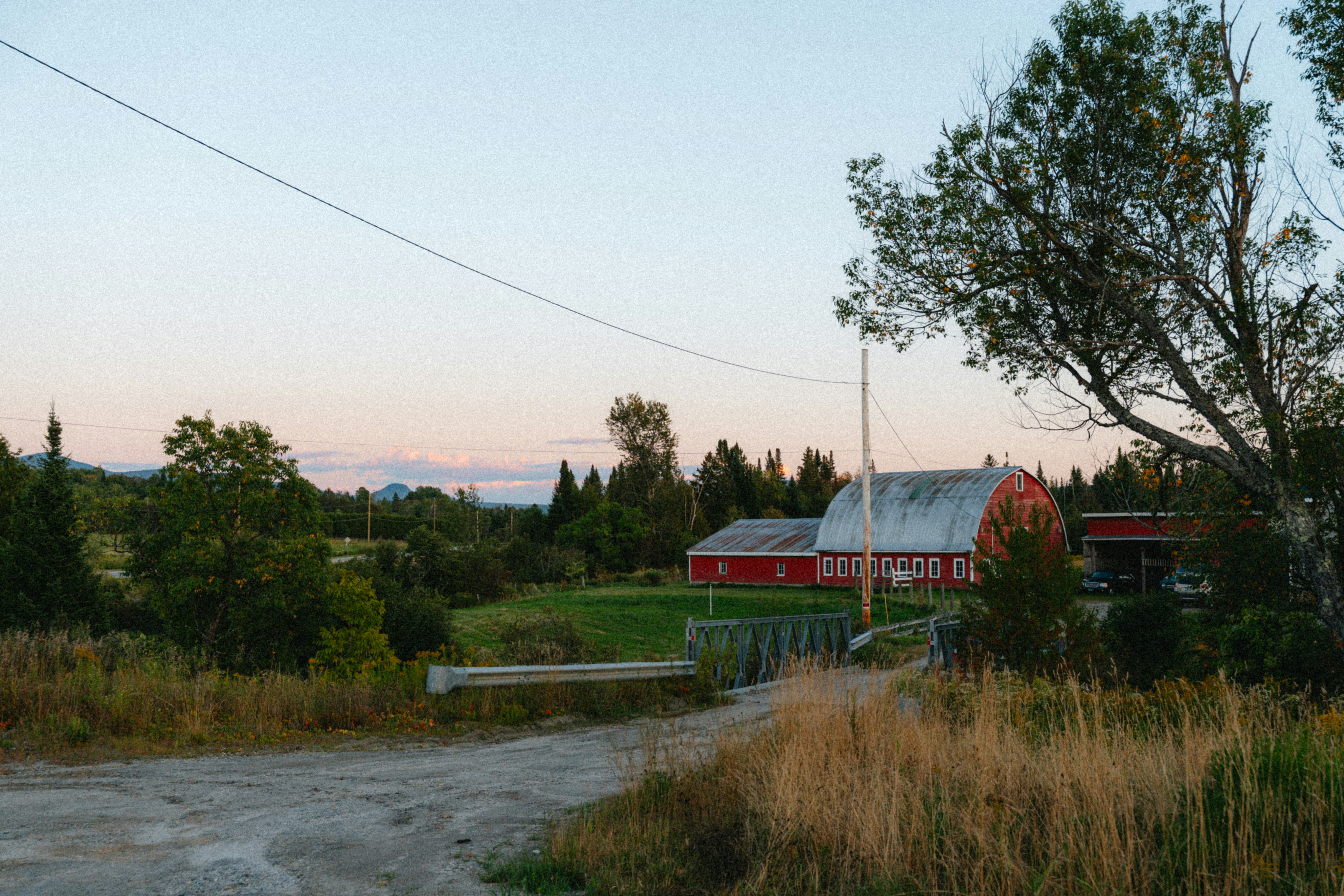 Red barn in a rural landscape at dusk.