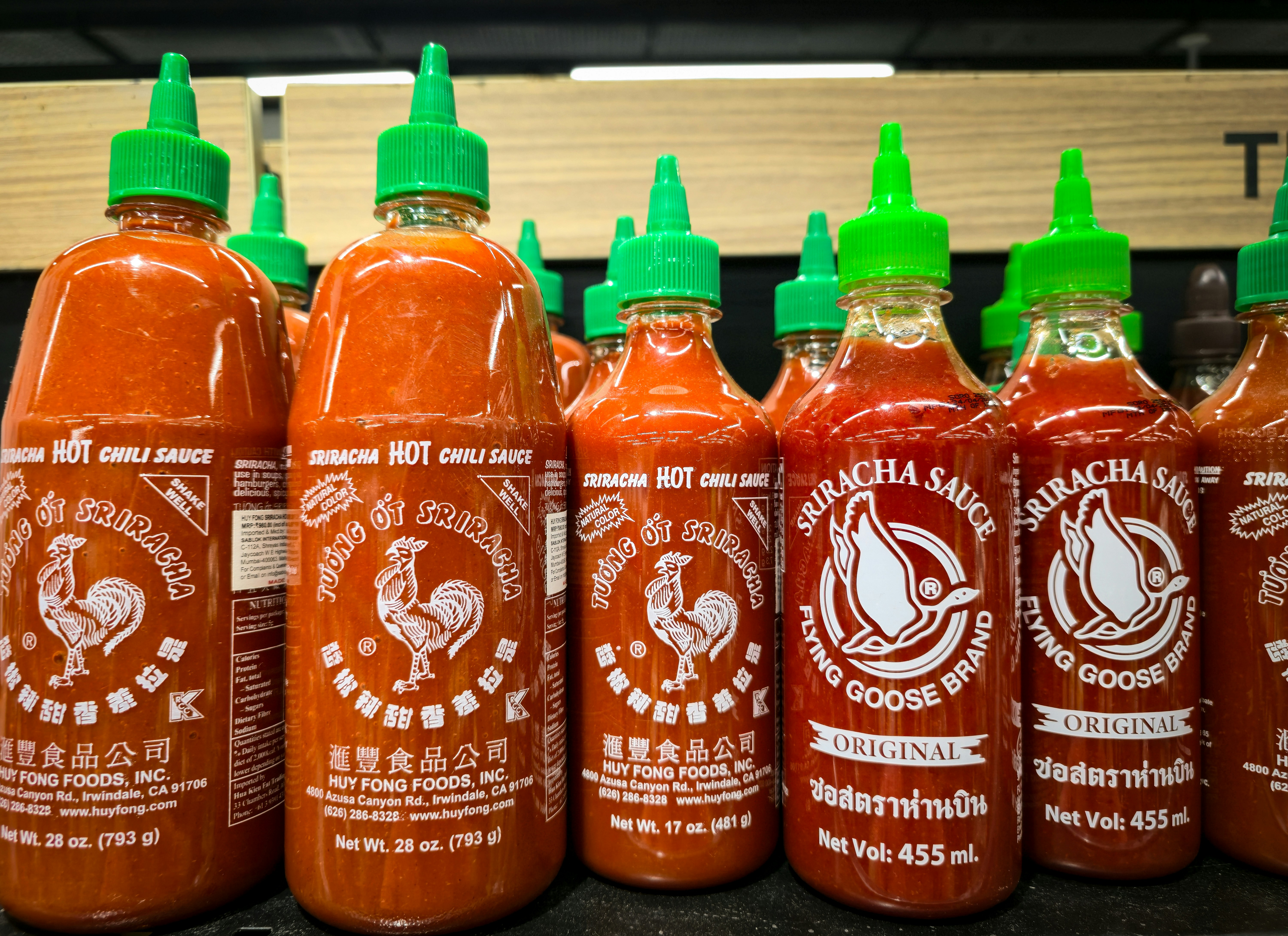 Several bottles of sriracha hot sauce lined up. photo – Free Food Image ...