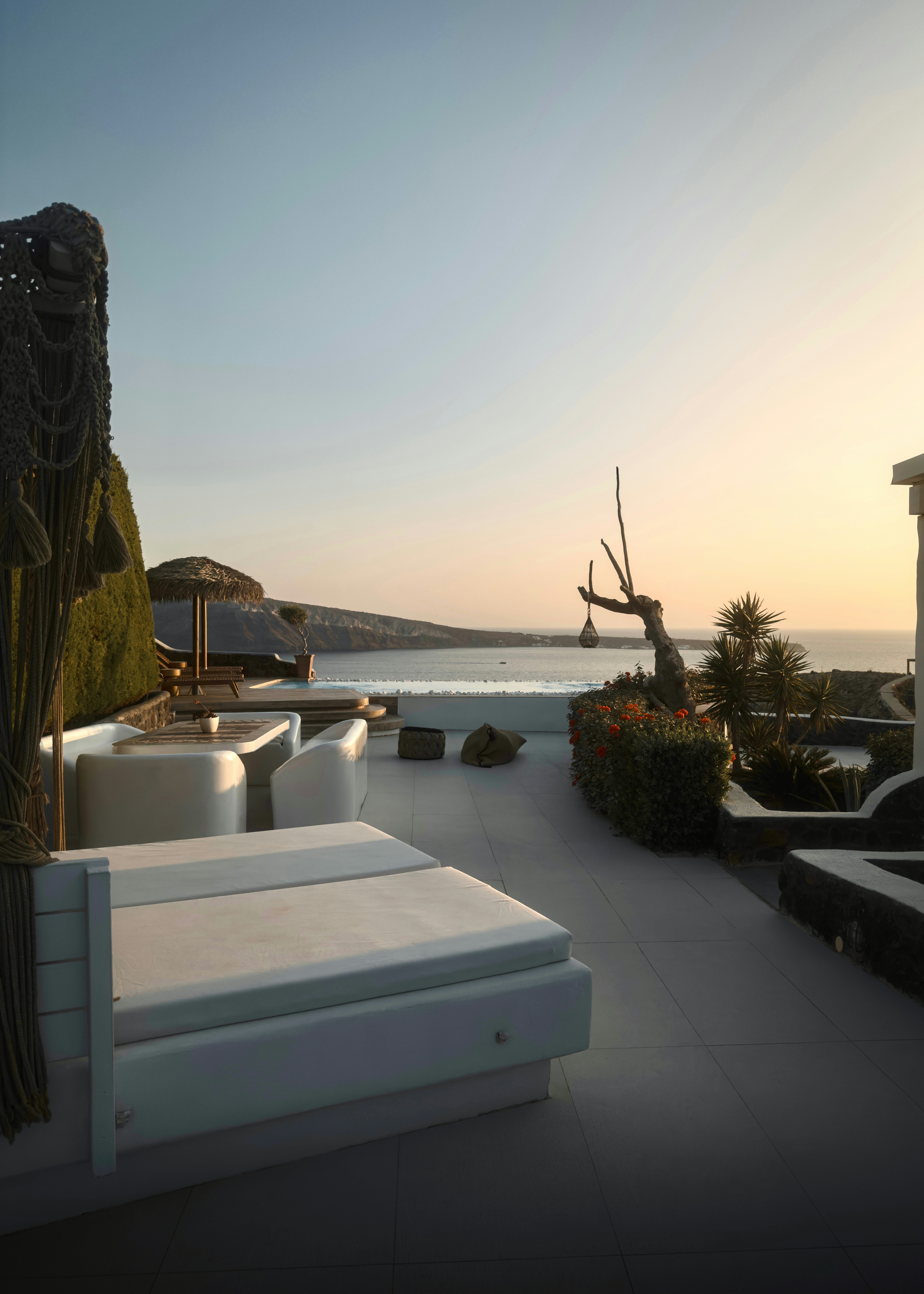 Luxury poolside lounge area overlooking the ocean at sunset. photo ...