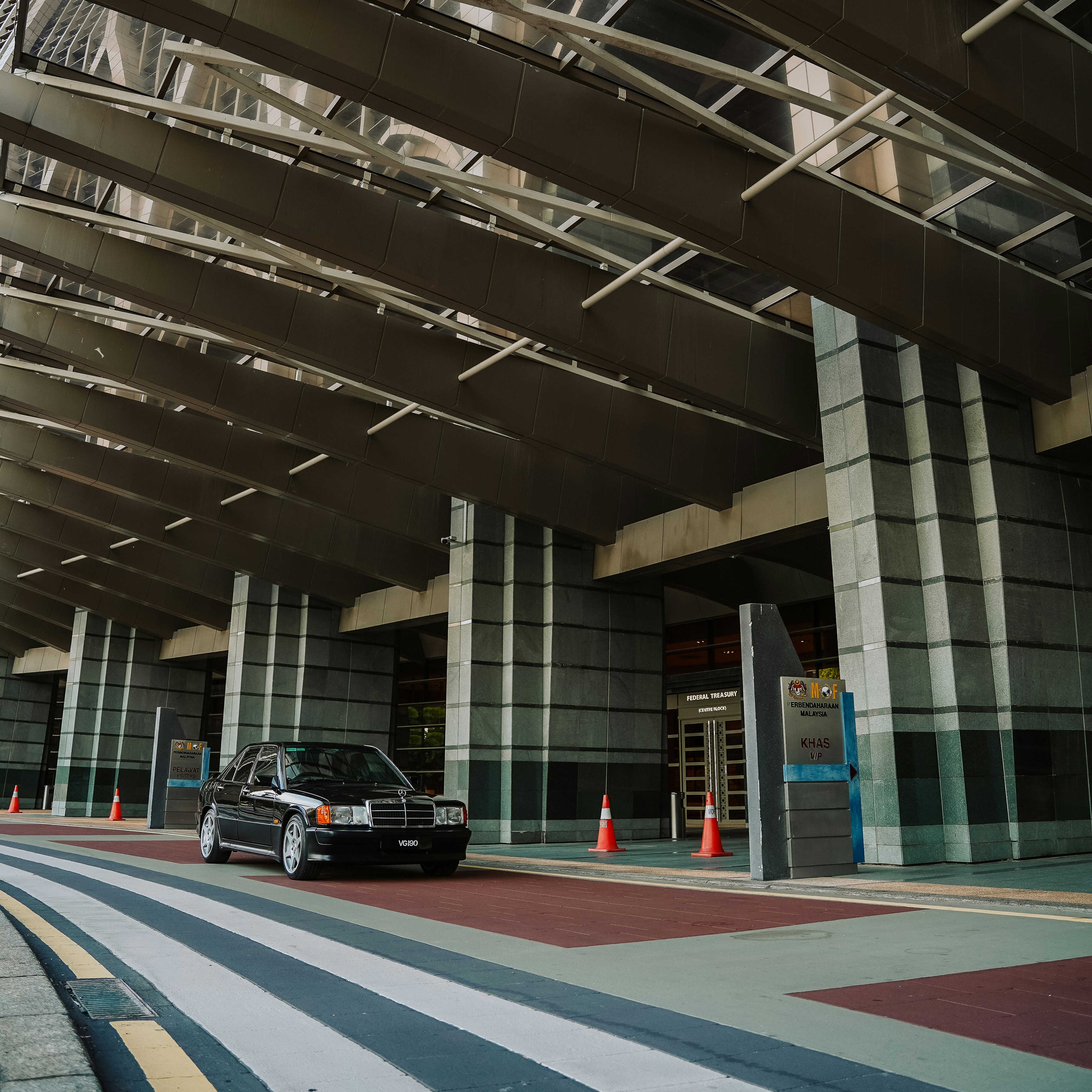 A vintage car drives under a modern building canopy. photo – Free ...