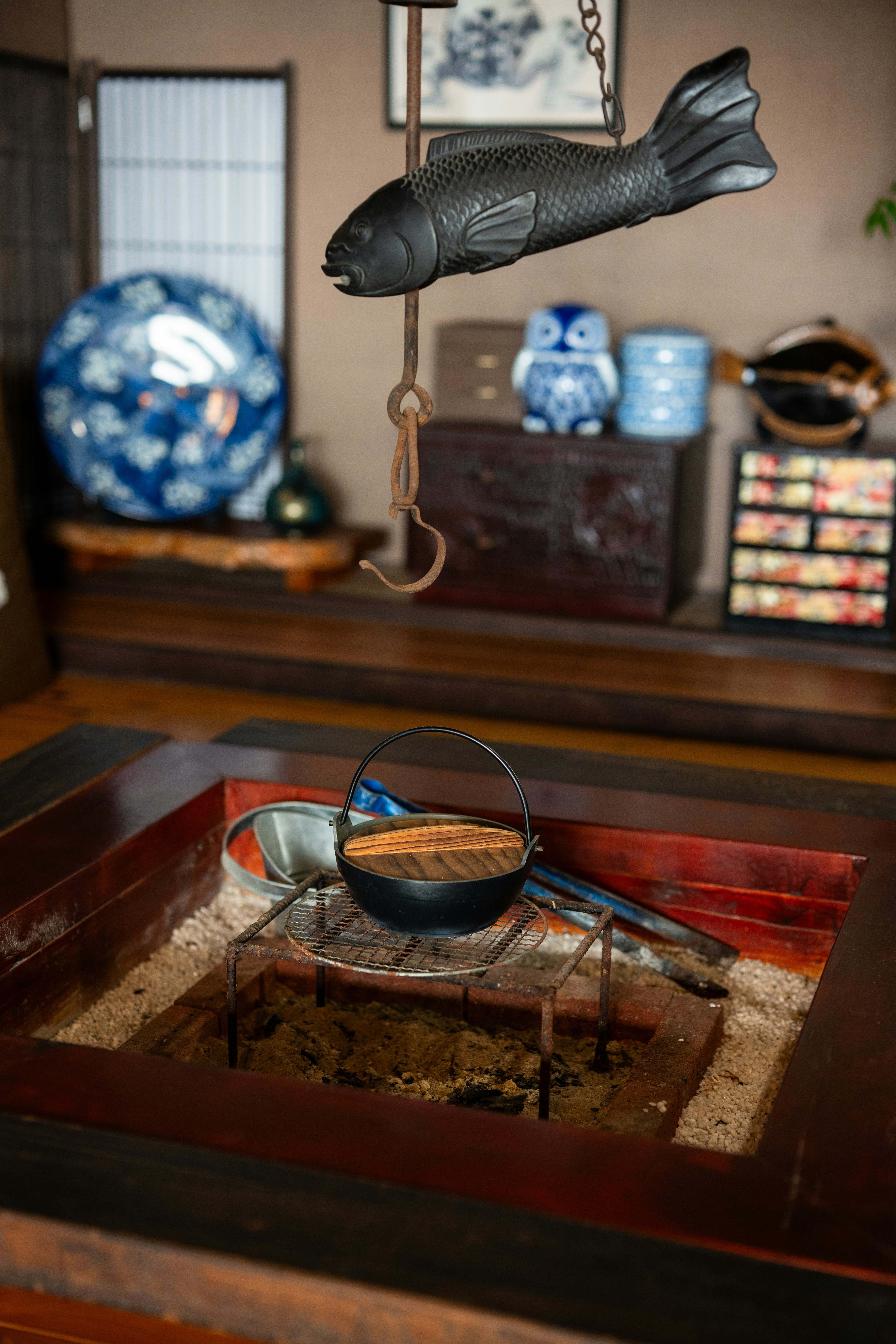 Traditional japanese hearth with cooking pot and fish decoration.