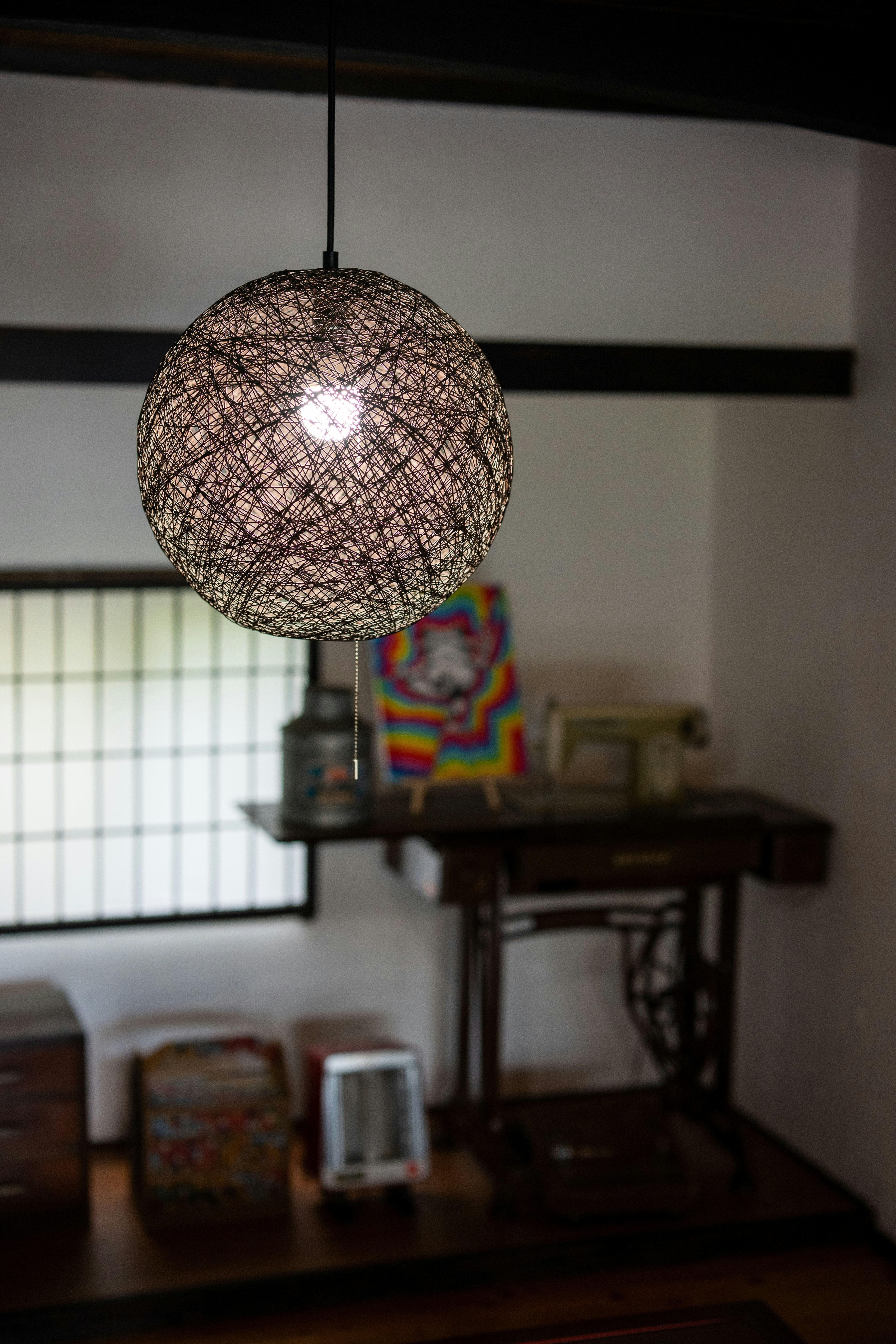 Tangled Glow: A Pendant Orb Illuminates a Quiet Vintage Workroom