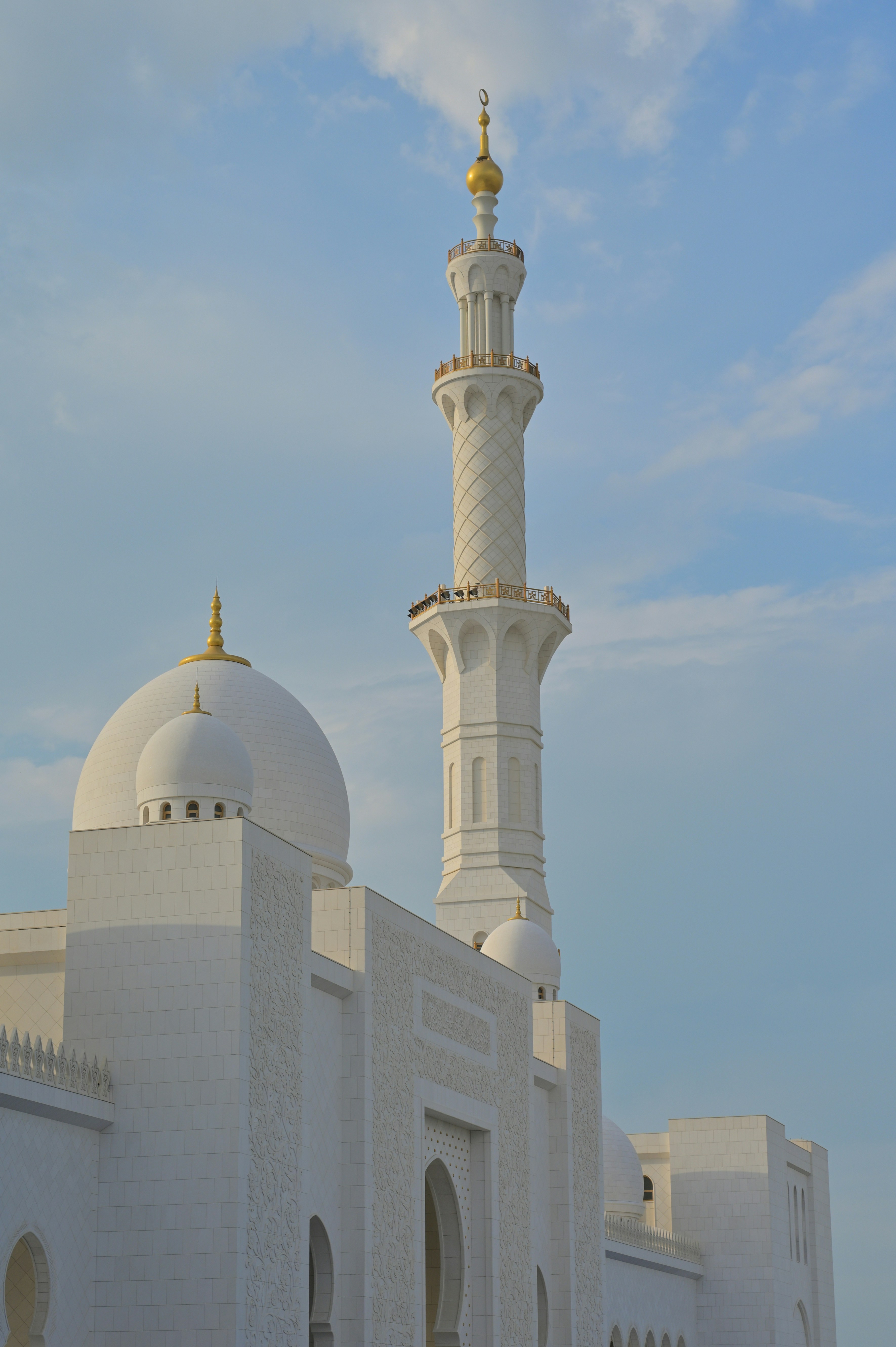 A white mosque with a tall minaret and dome.