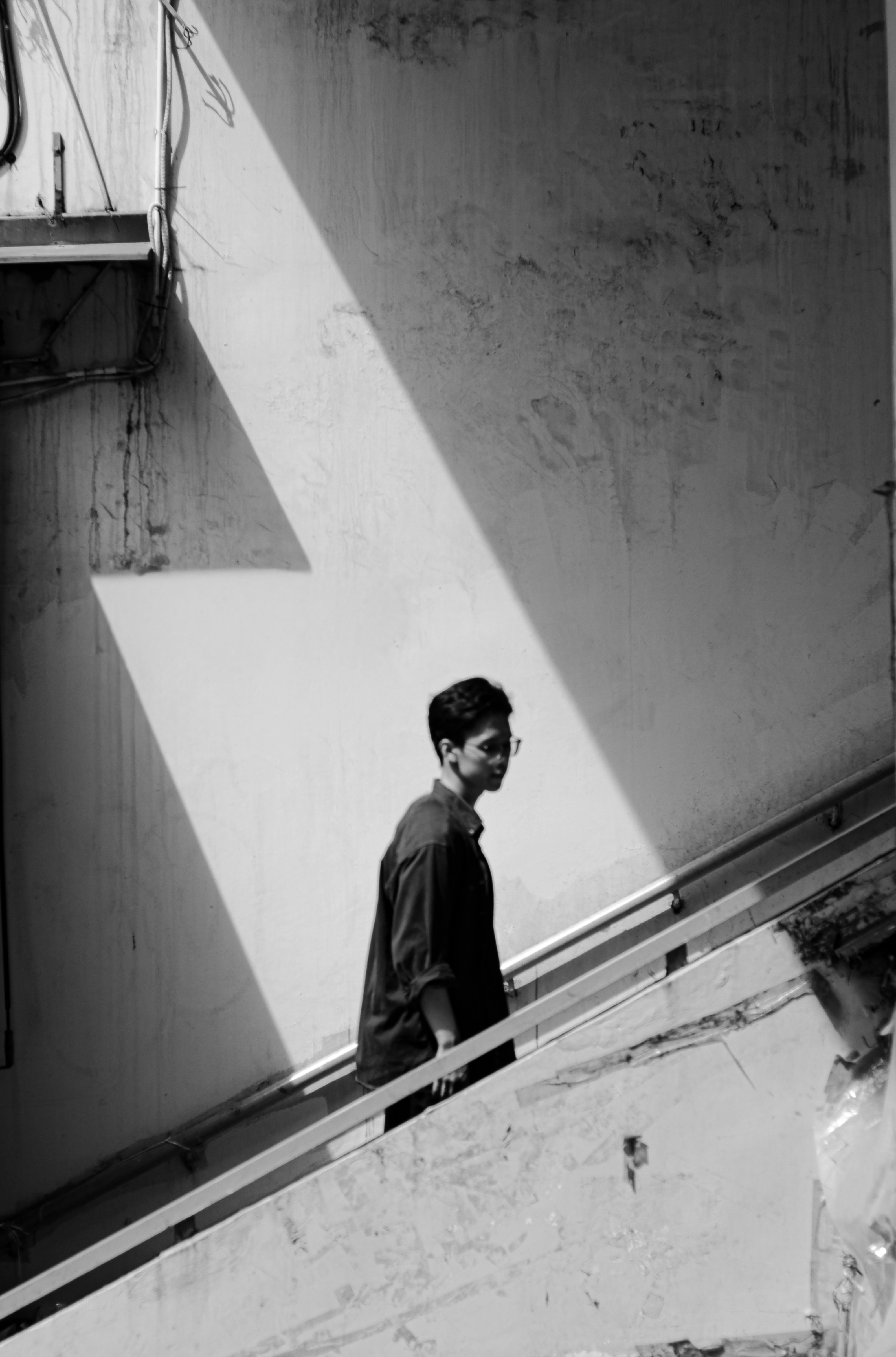 Man walking up stairs in stark sunlight and shadow