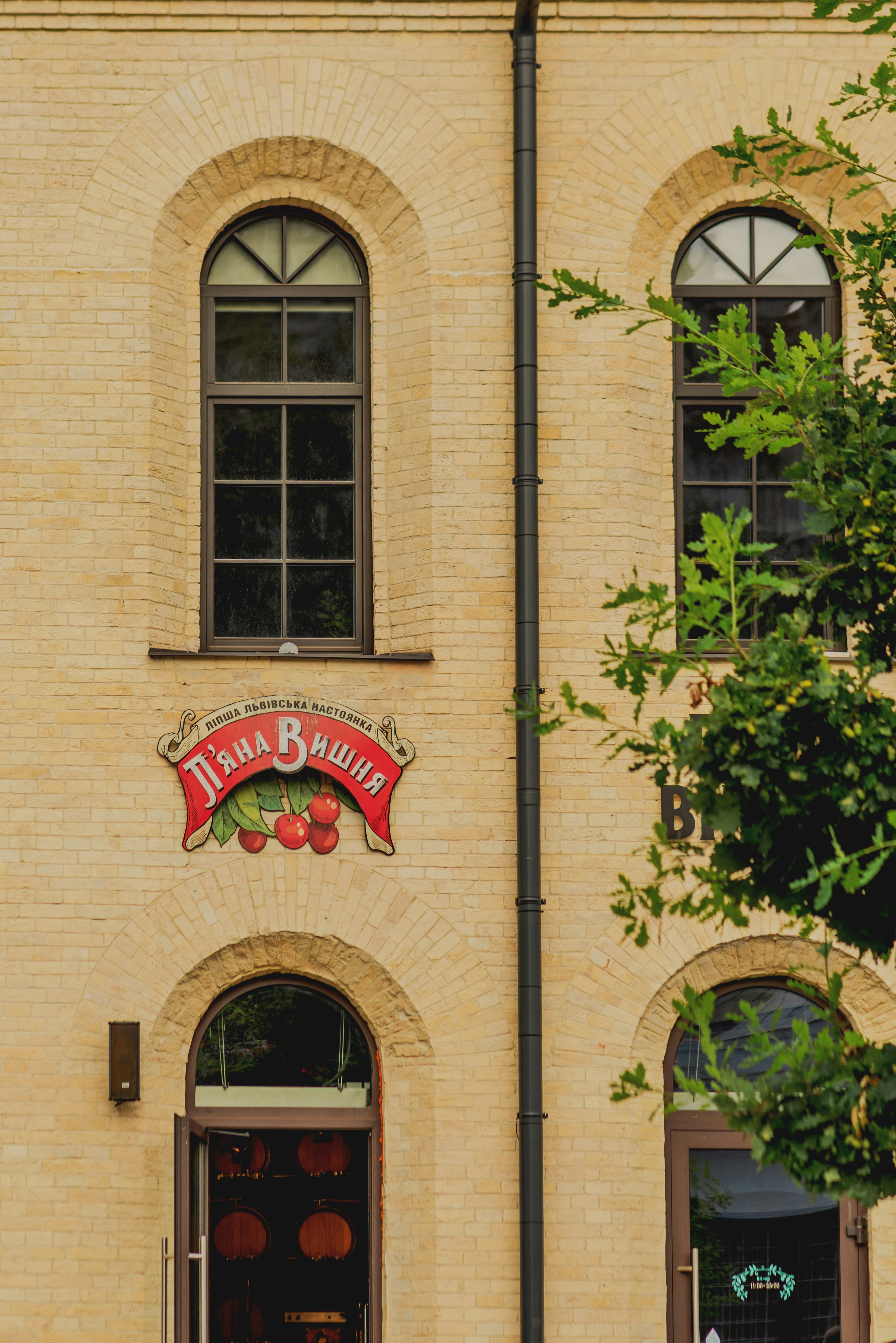 Cherry Sign Adorns a Sunlit Brick Facade Beneath Arched Windows