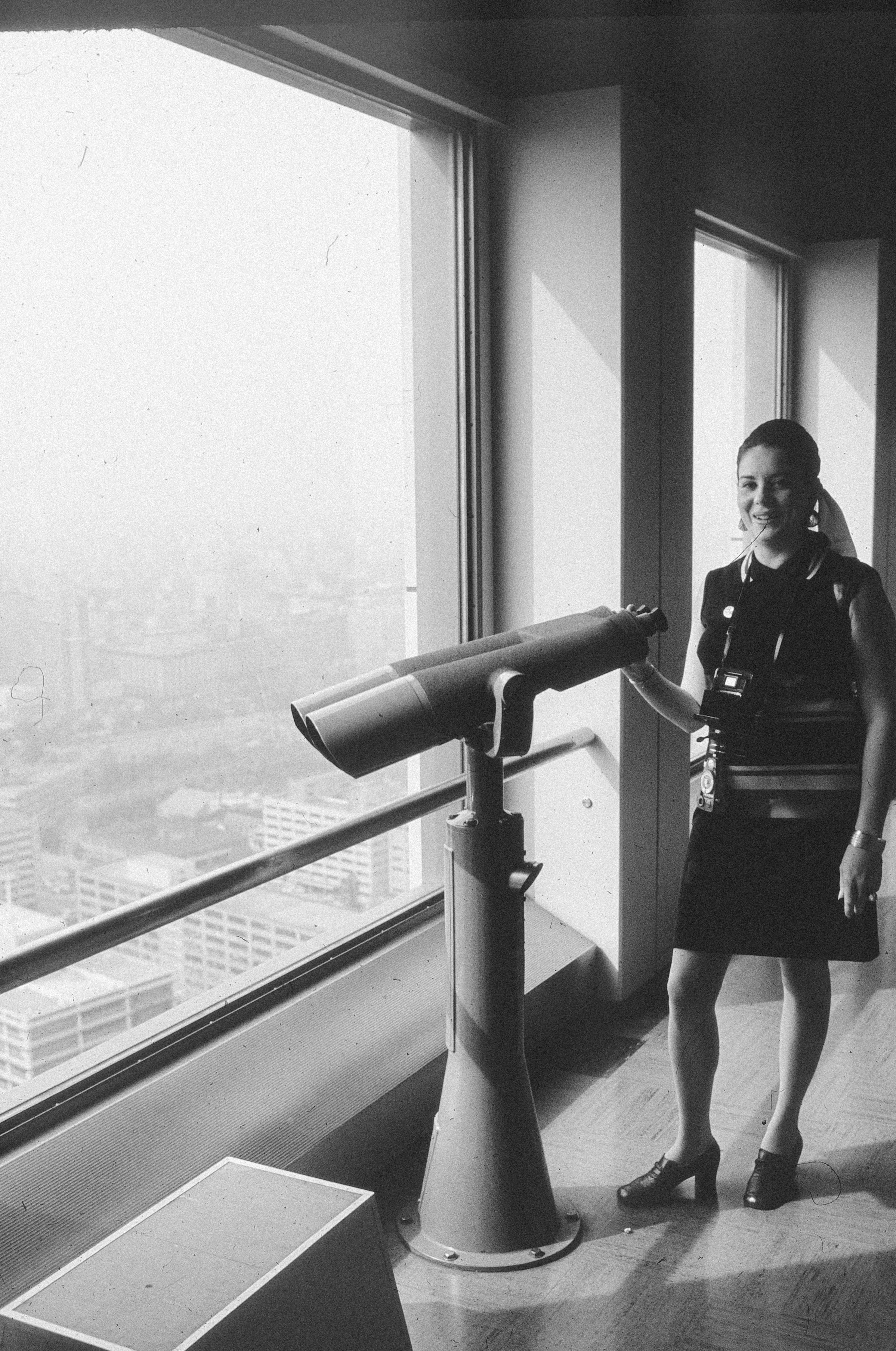 Woman looking through a telescope from a high window. photo – Free ...