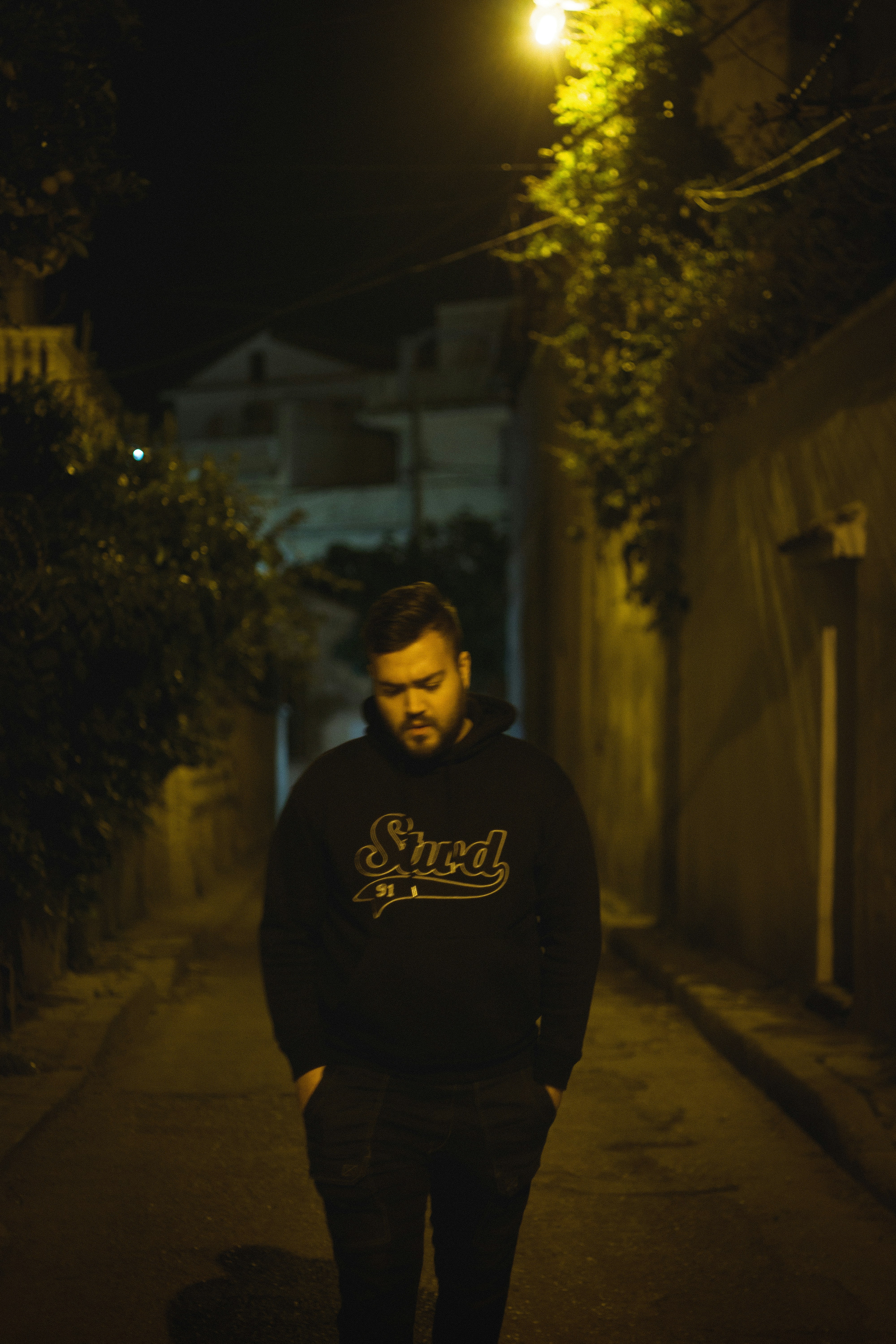Man standing in a dimly lit street at night. photo – Free Image on Unsplash