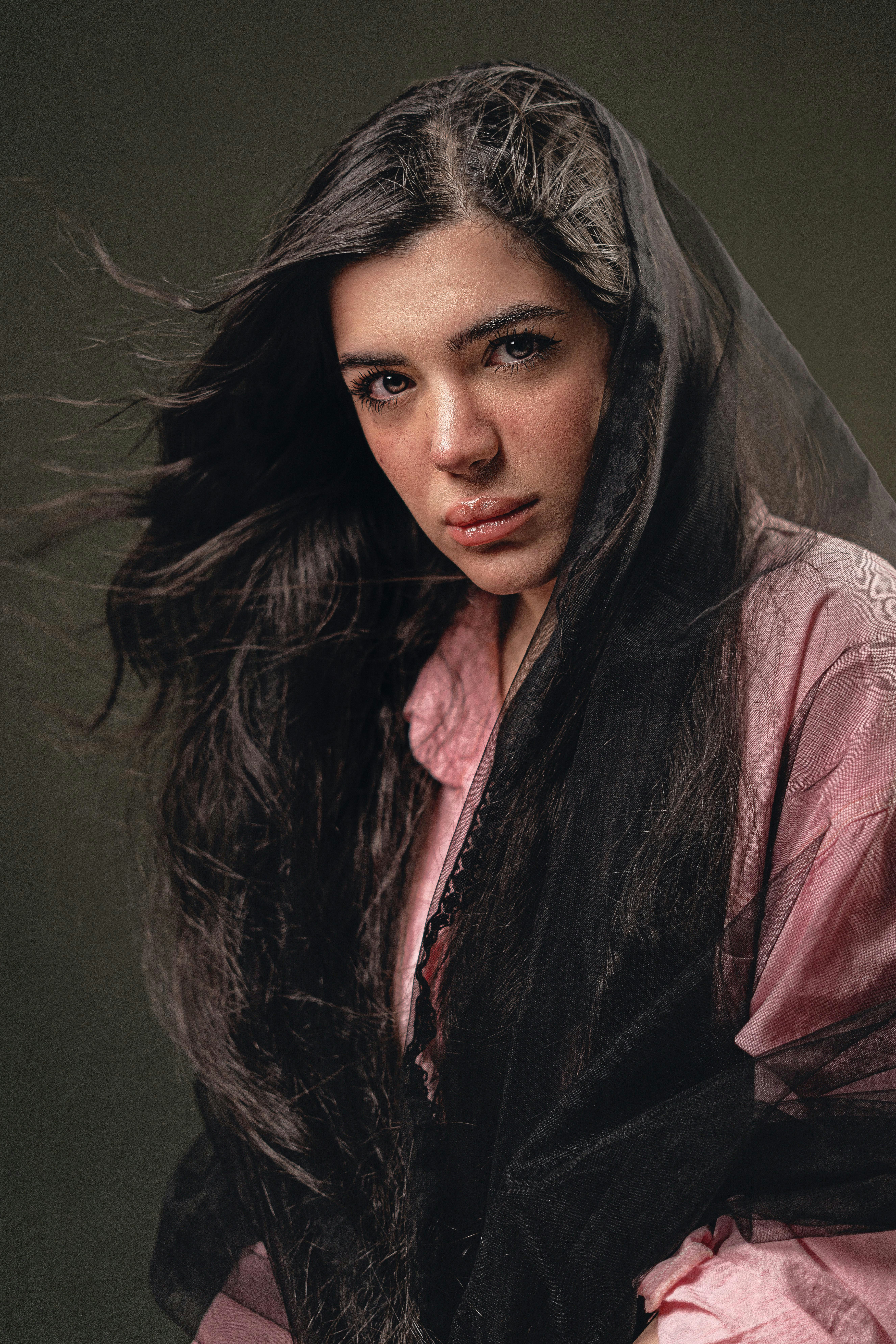 Young woman with dark hair and veil