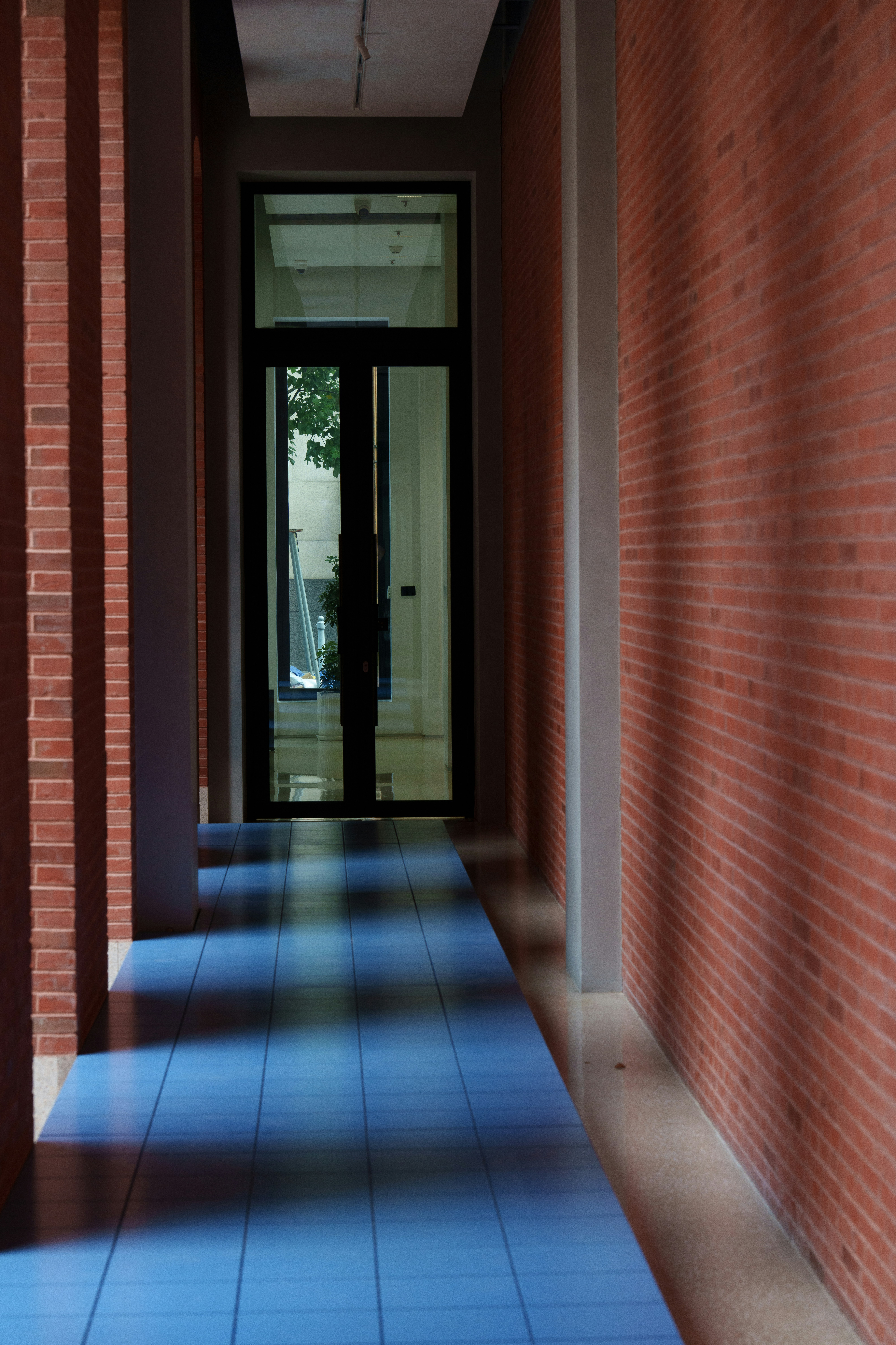 Hallway with brick walls and blue tiled floor