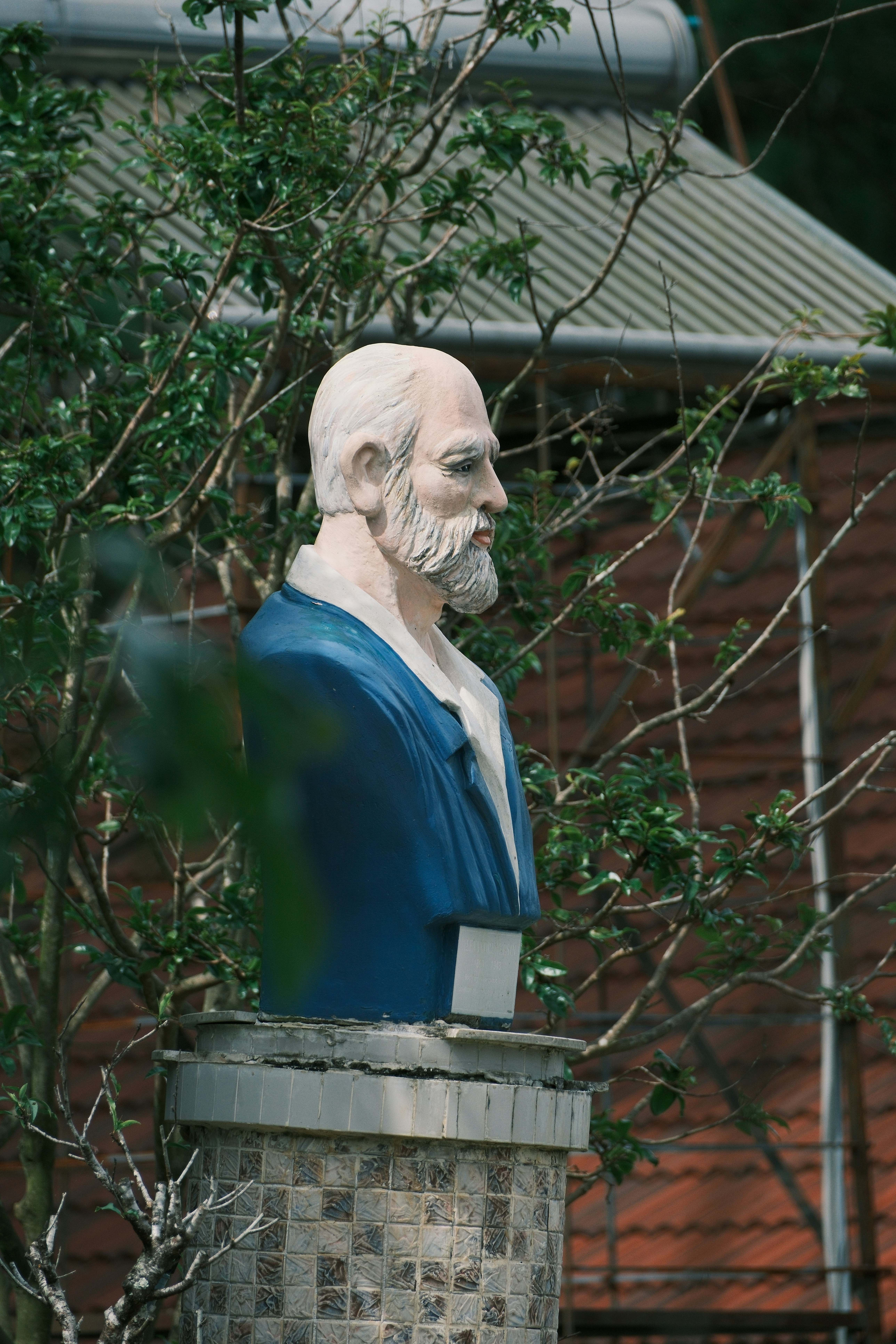 A Silent Sentinel: The Bust Amongst the Leaves