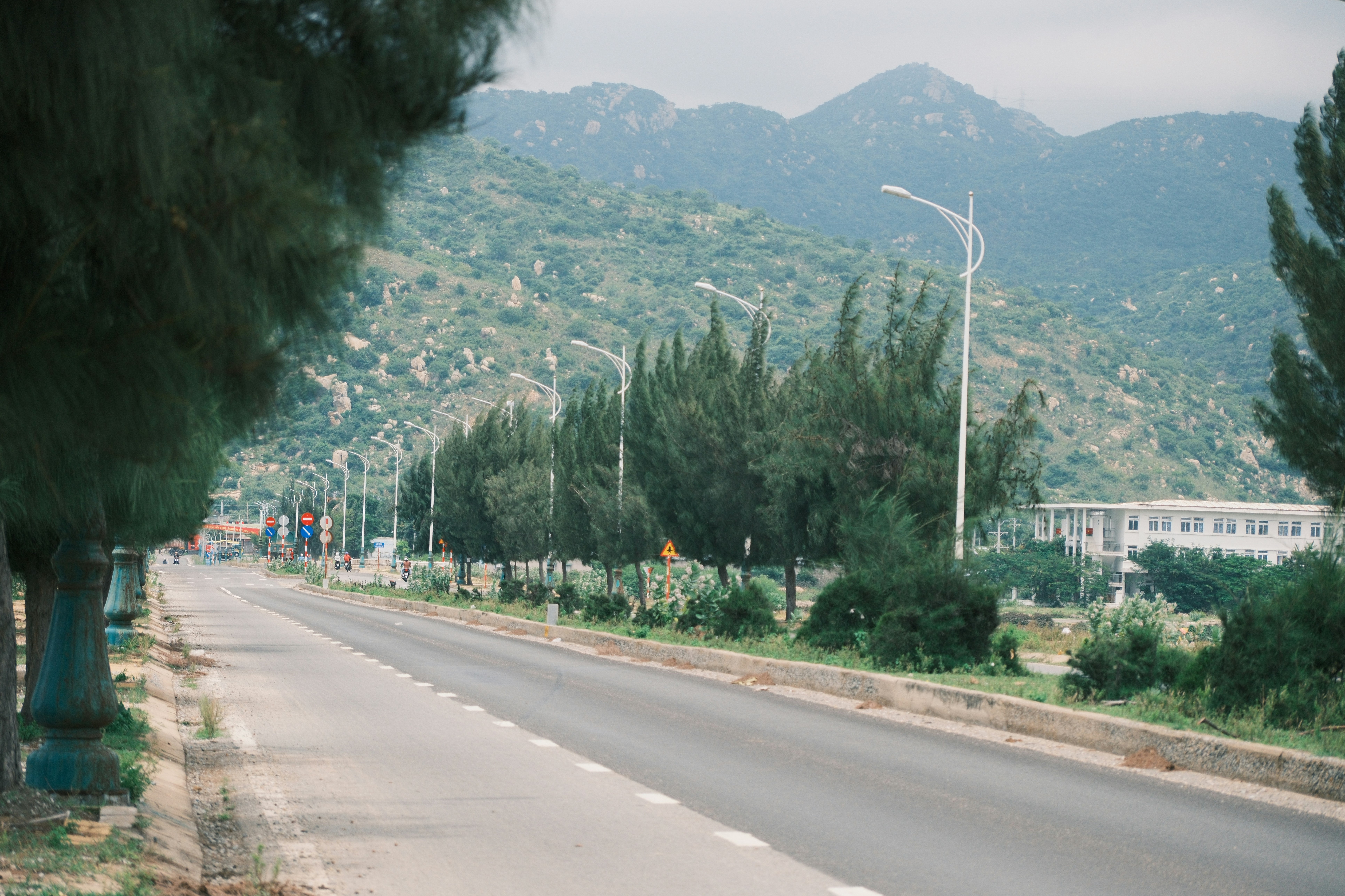 A scenic road leads towards distant mountains.