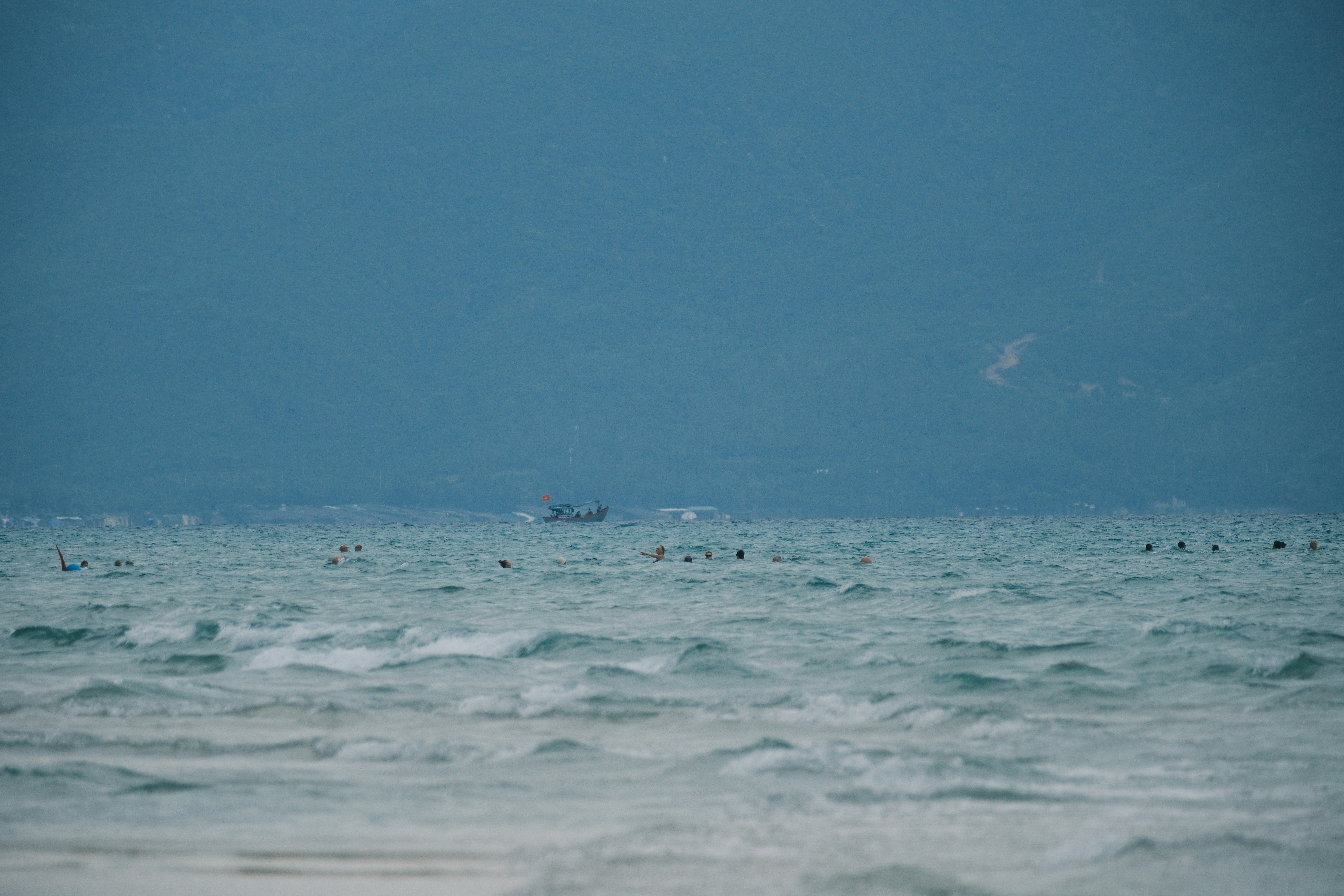 Small boat on a choppy sea with distant mountains photo – Free Image on ...