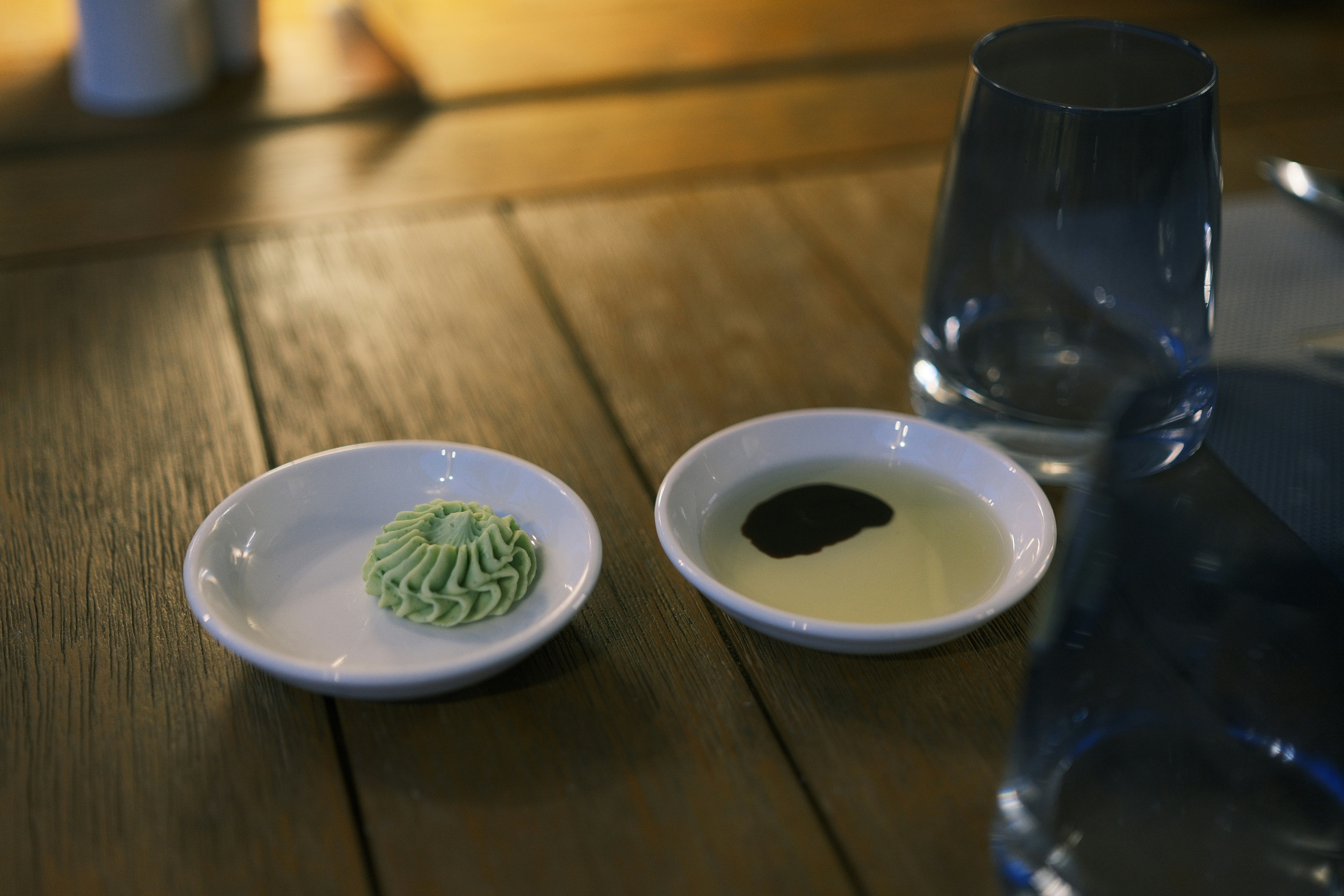 Two small dishes with sauce and wasabi