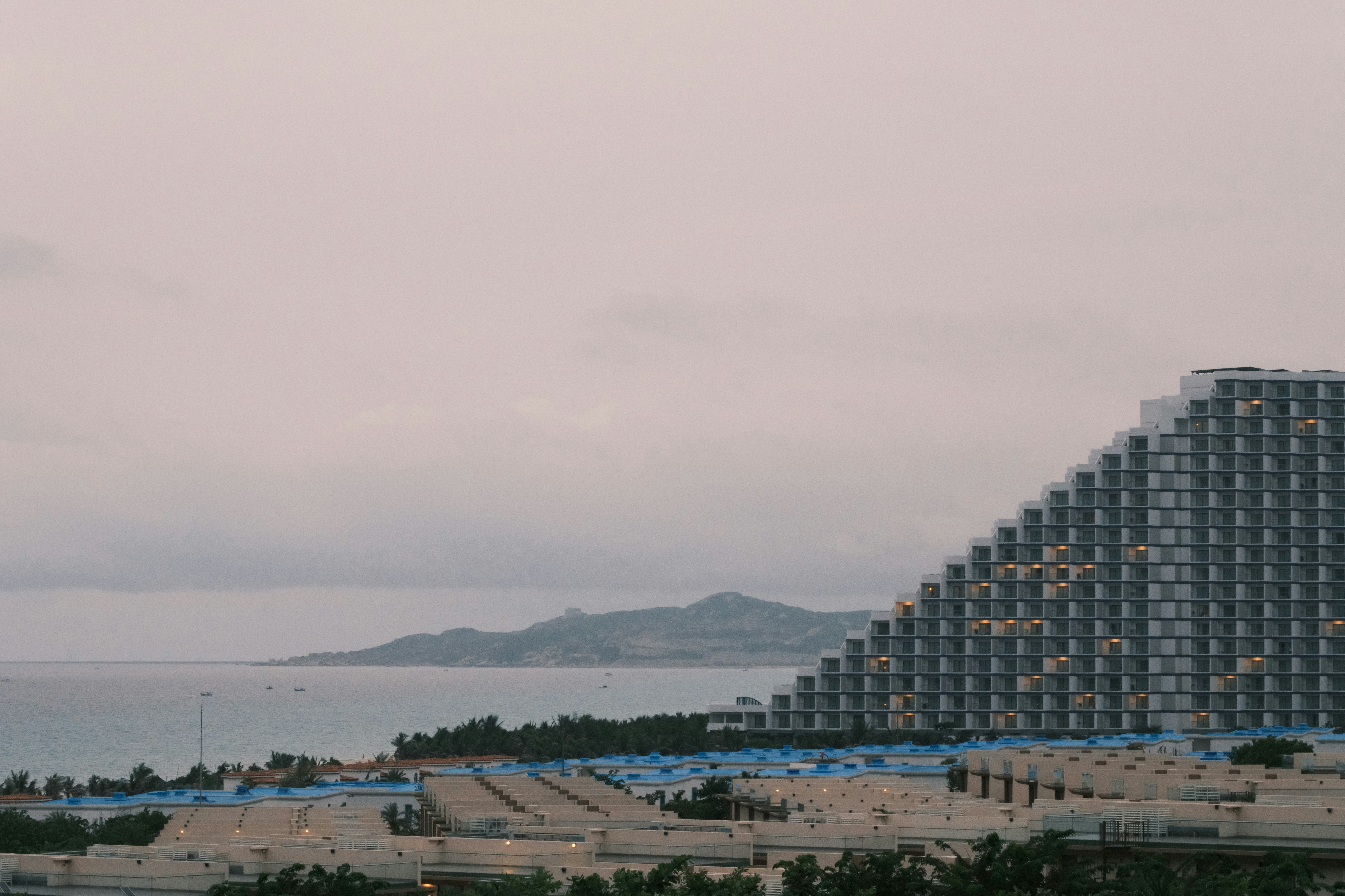Tiered Horizons: A Pyramid of Balconies Rises Along a Quiet Seaside
