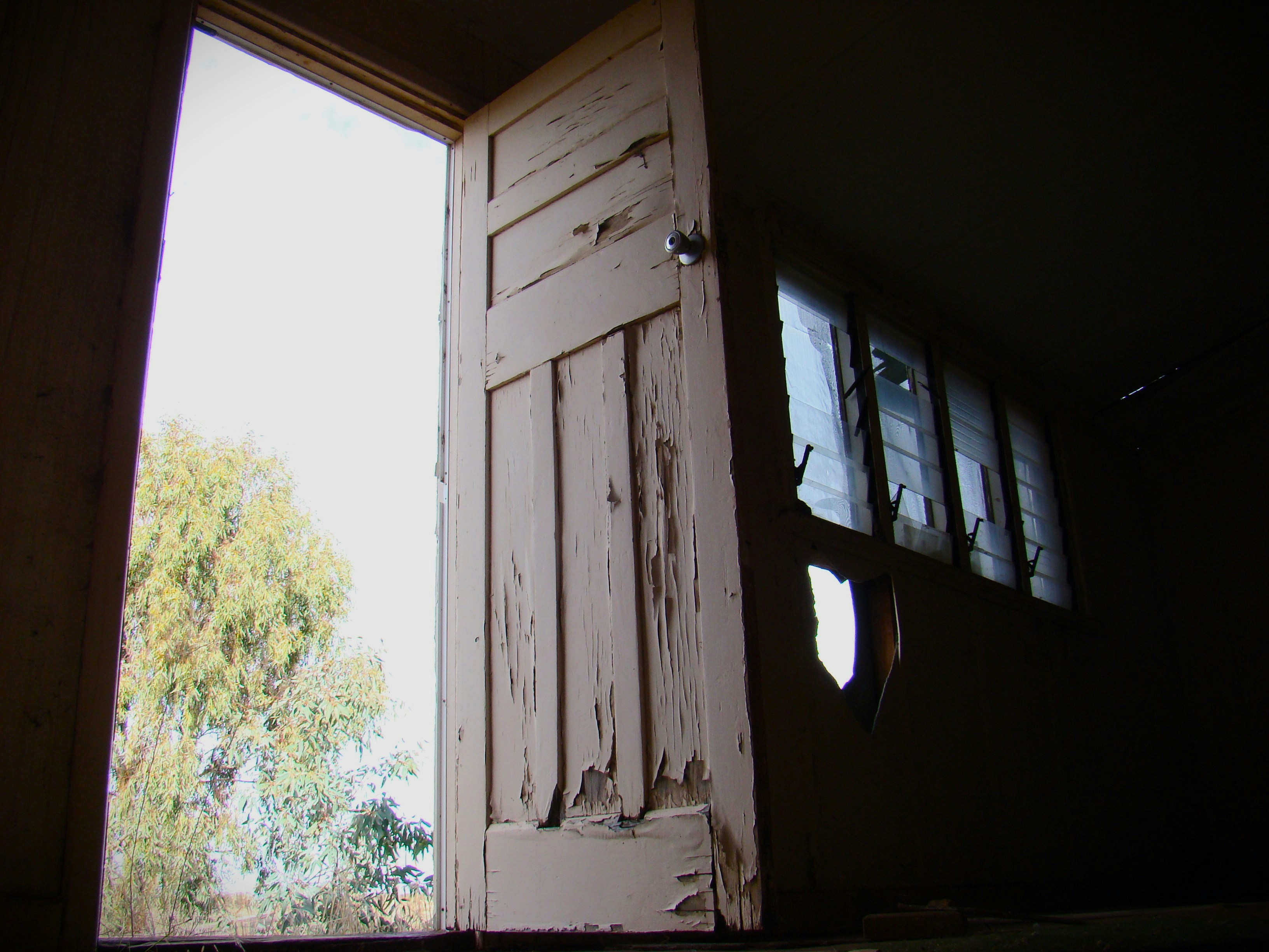 Open doorway into a dark, weathered room