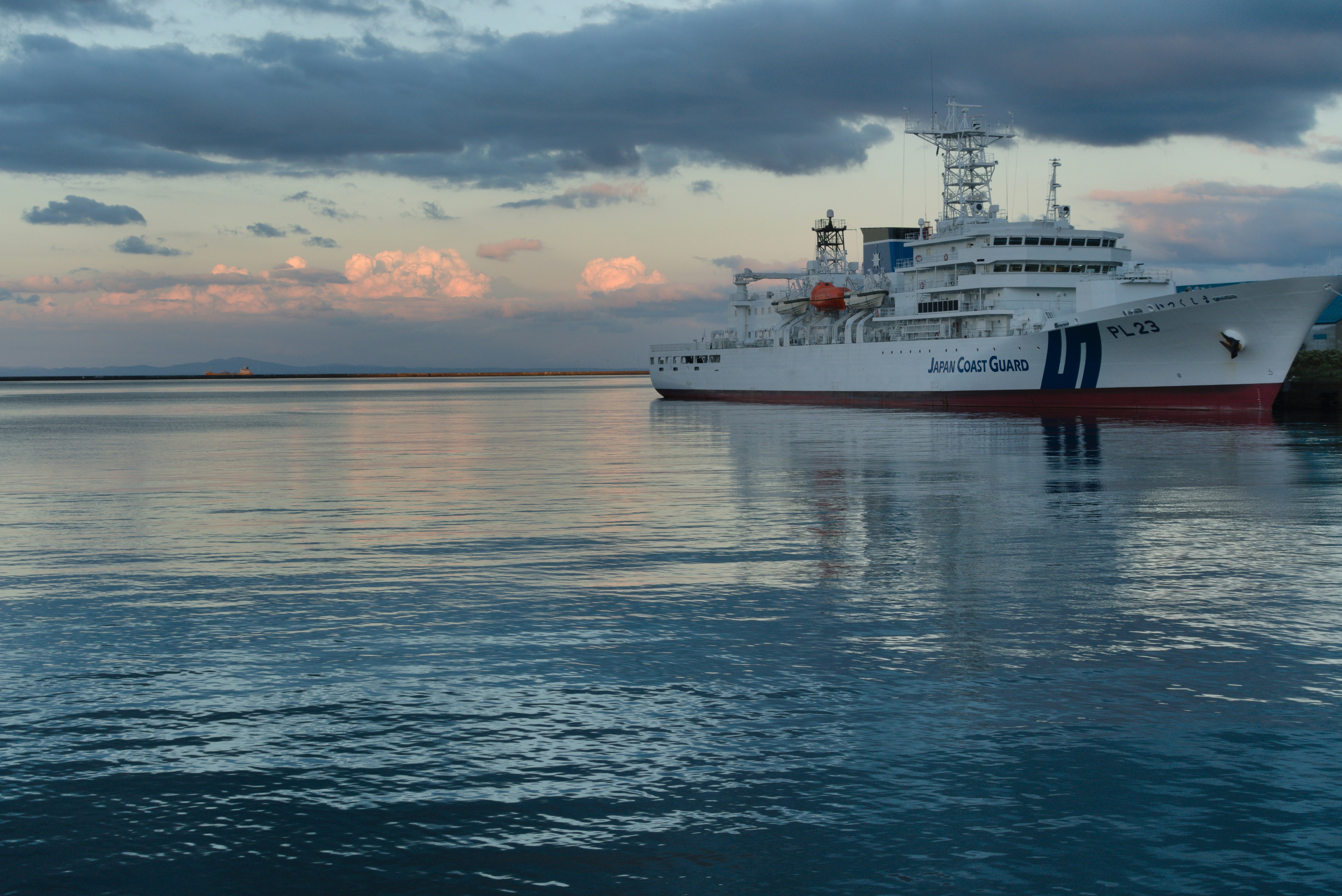 Japanese coast guard docked in Otaru at sunset | White ship docked at the harbor during sunset