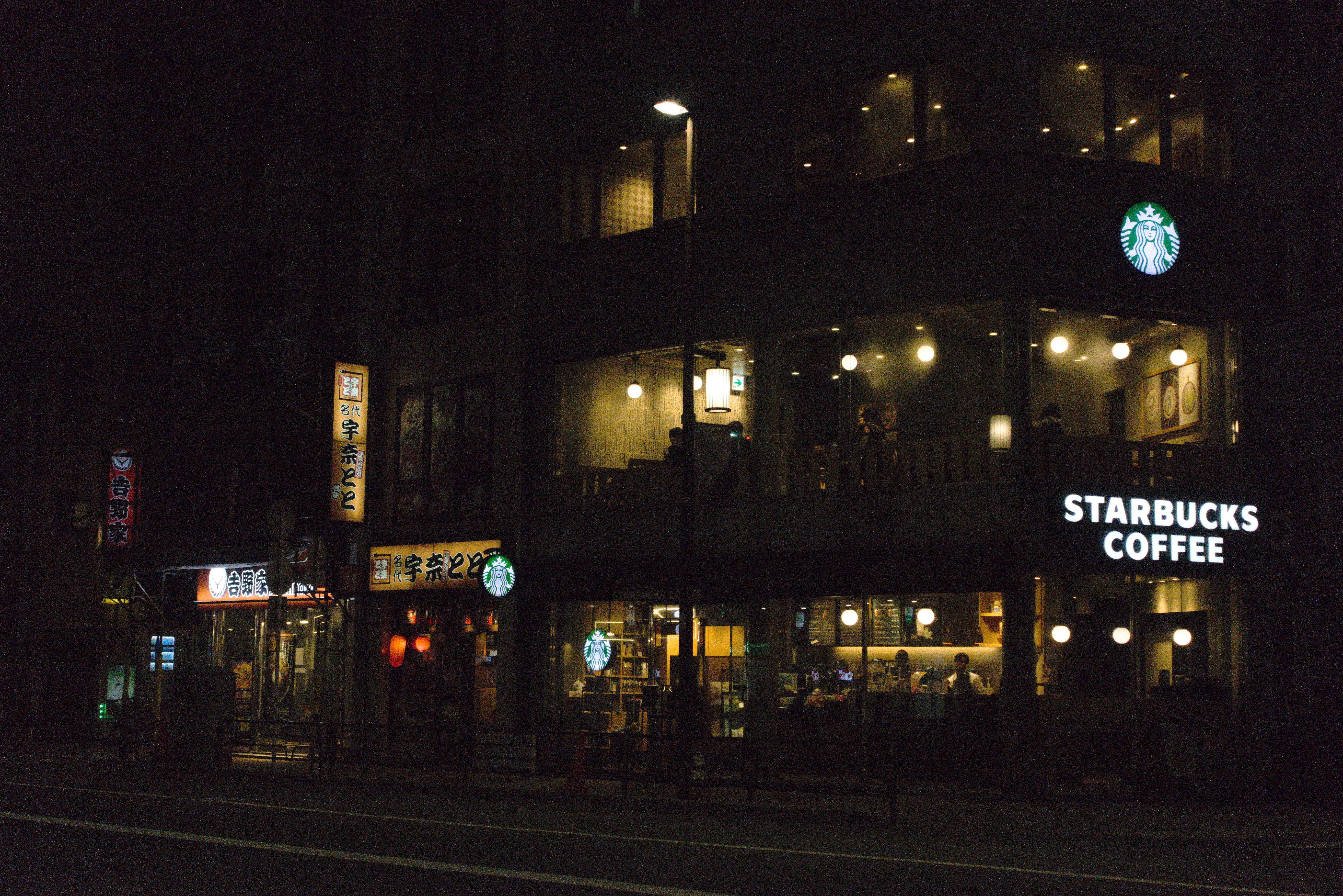 Starbucks coffee shop at night with people inside.