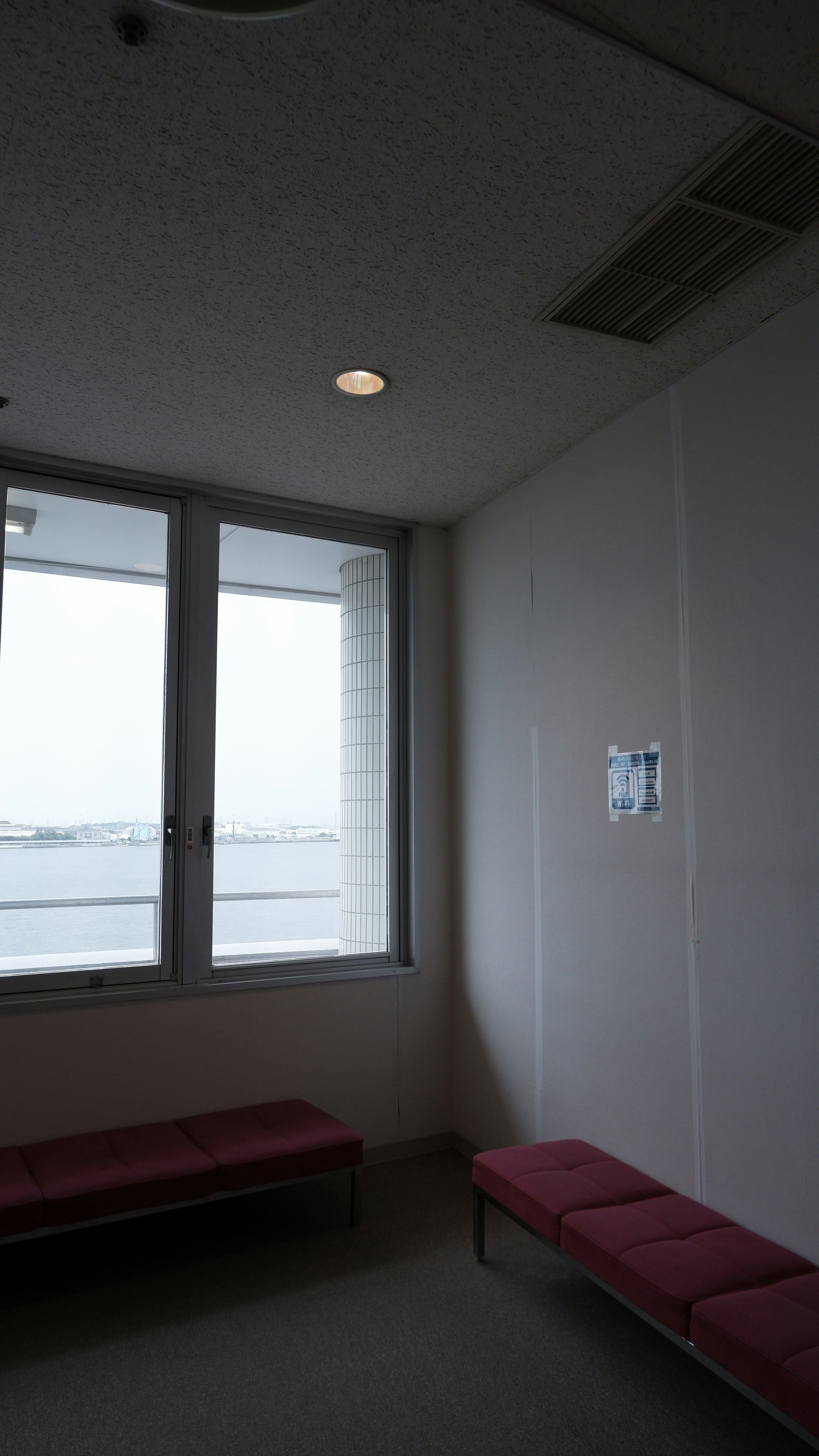 Sea Horizon Through a Quiet Waiting Room with Pink Benches