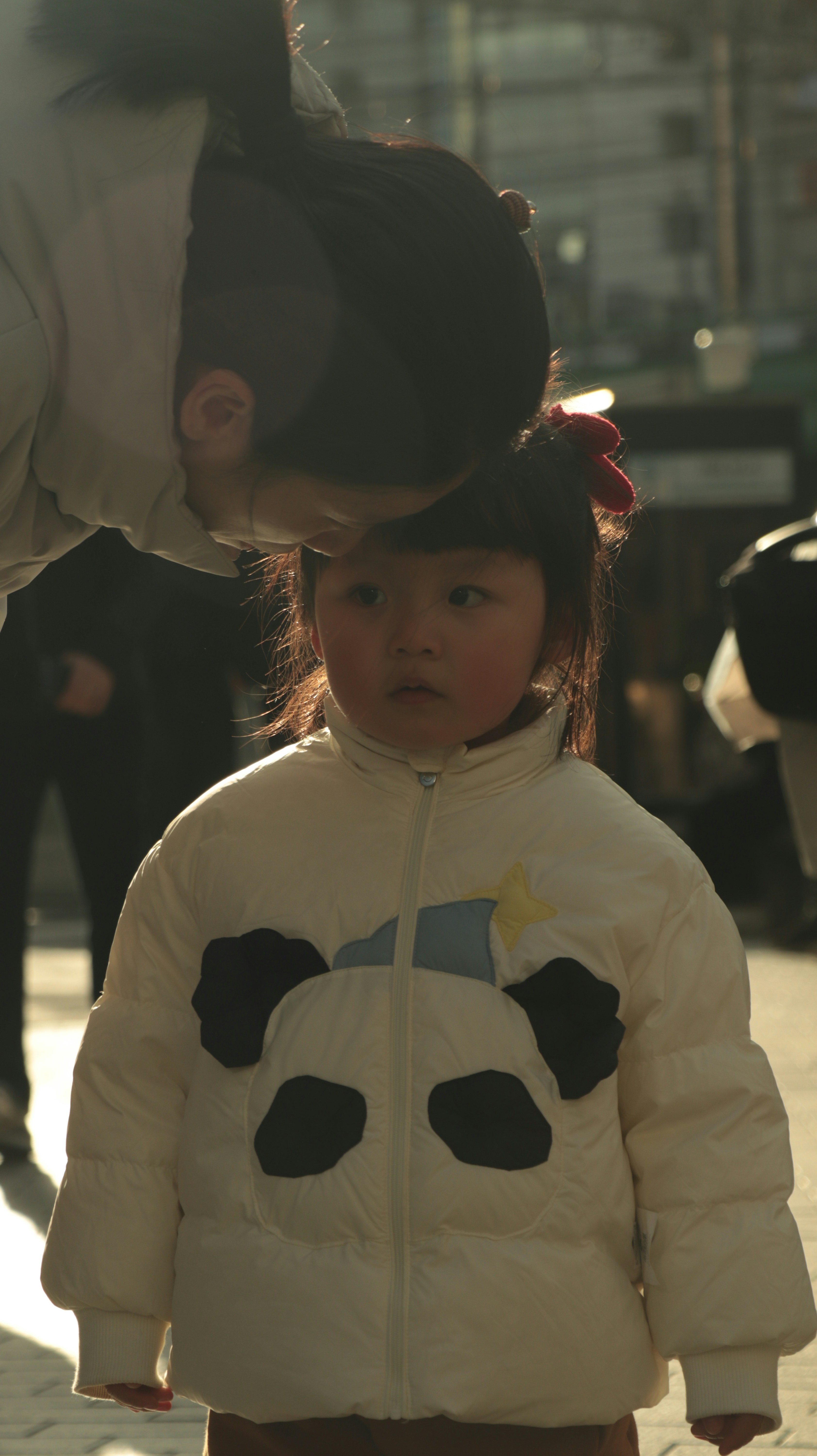 A child in a panda jacket looks forward.