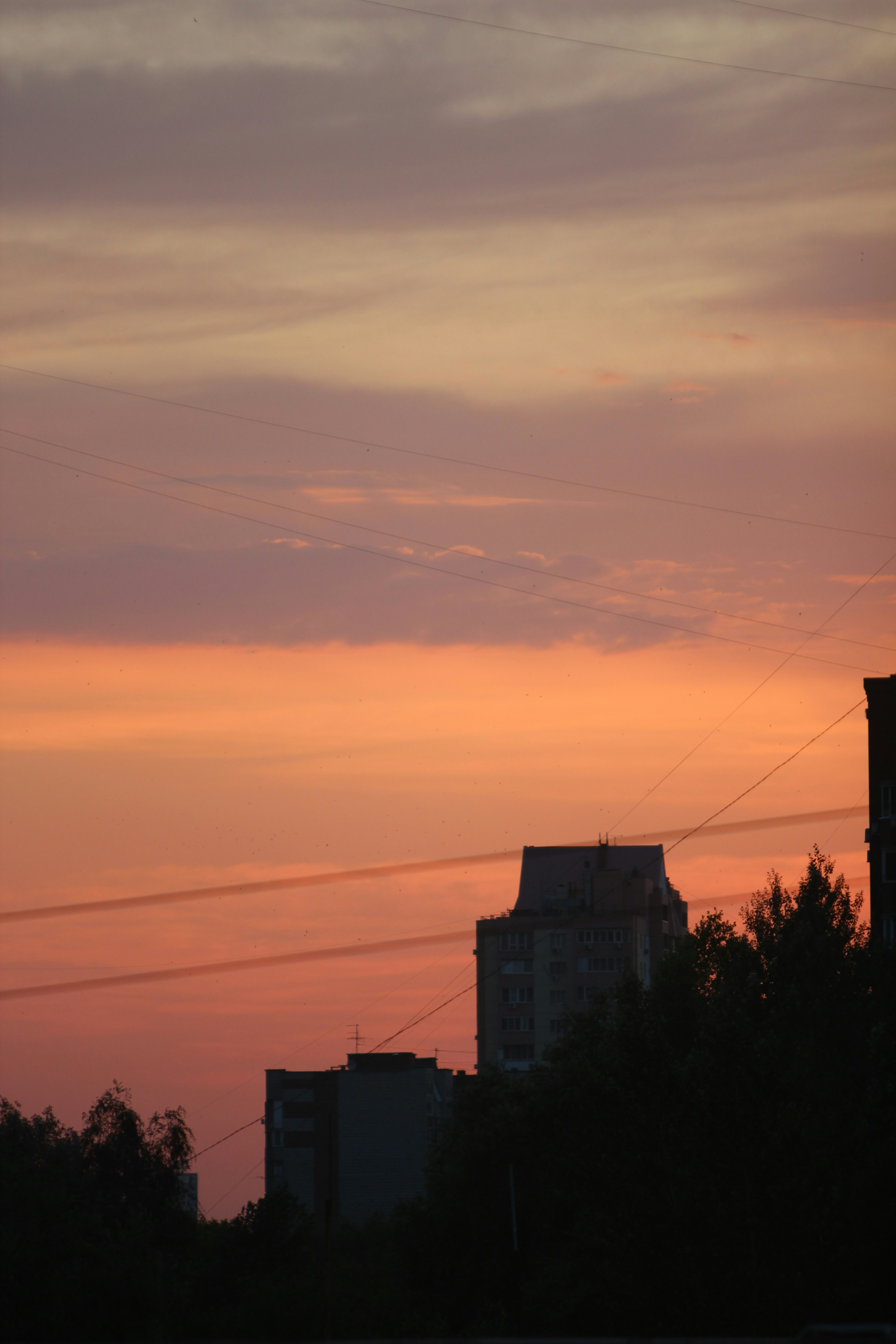 Buildings silhouetted against a colorful sunset sky.